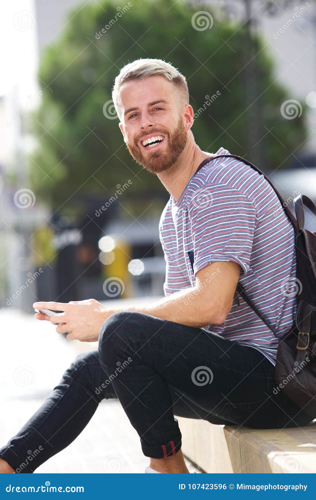 Smiling Male University Student Sitting Outside with Mobile Phone Stock ... Smiling Male University Student Sitting Outside with Mobile Phone Stock ...