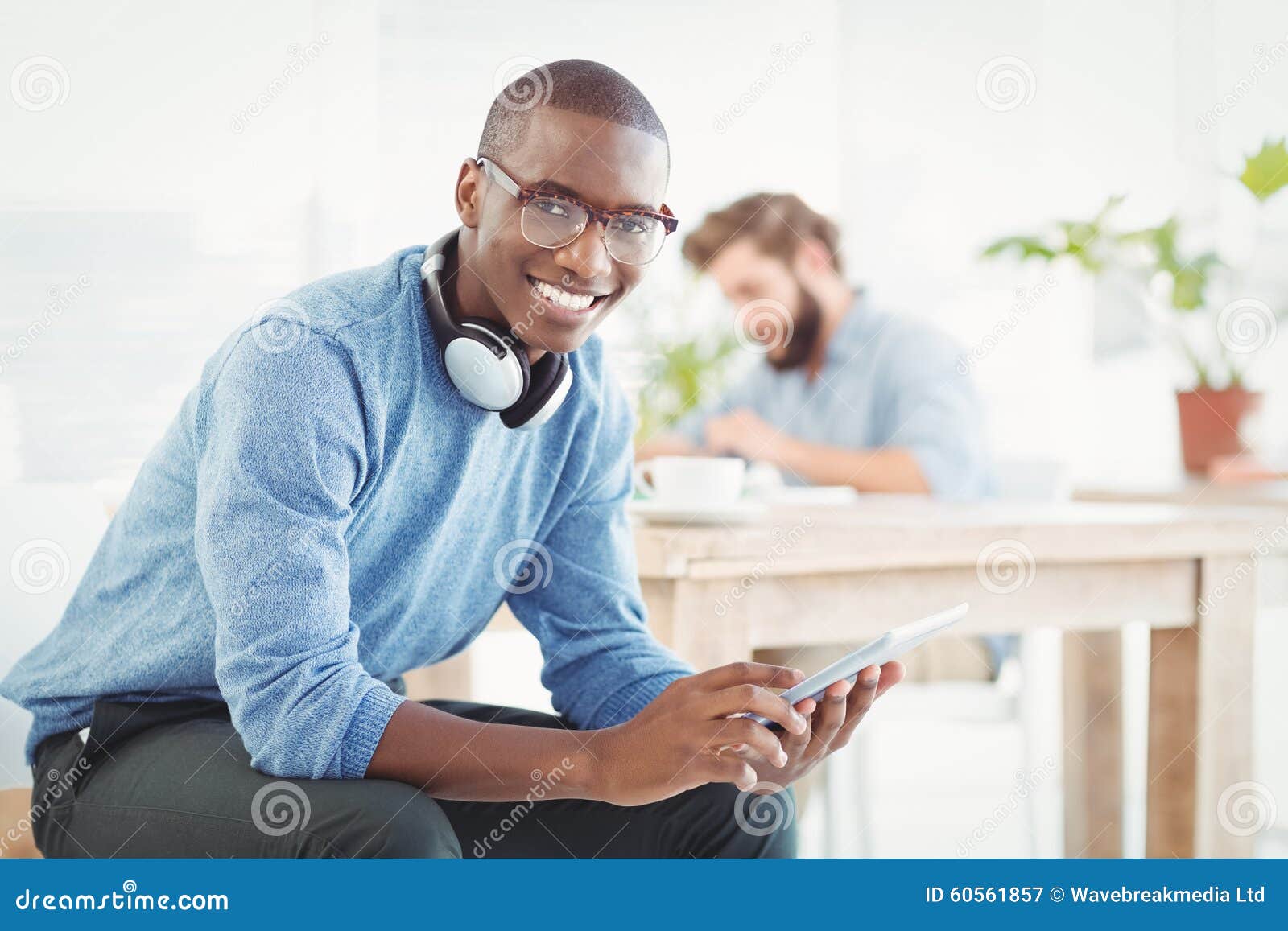Portrait of Smiling Man with Headphones while Using Digital Tablet ...