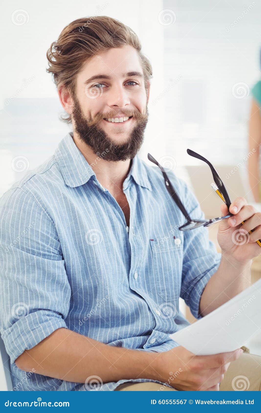 Portrait Of Smiling Man Holding Eyeglasses And Paper Stock Image