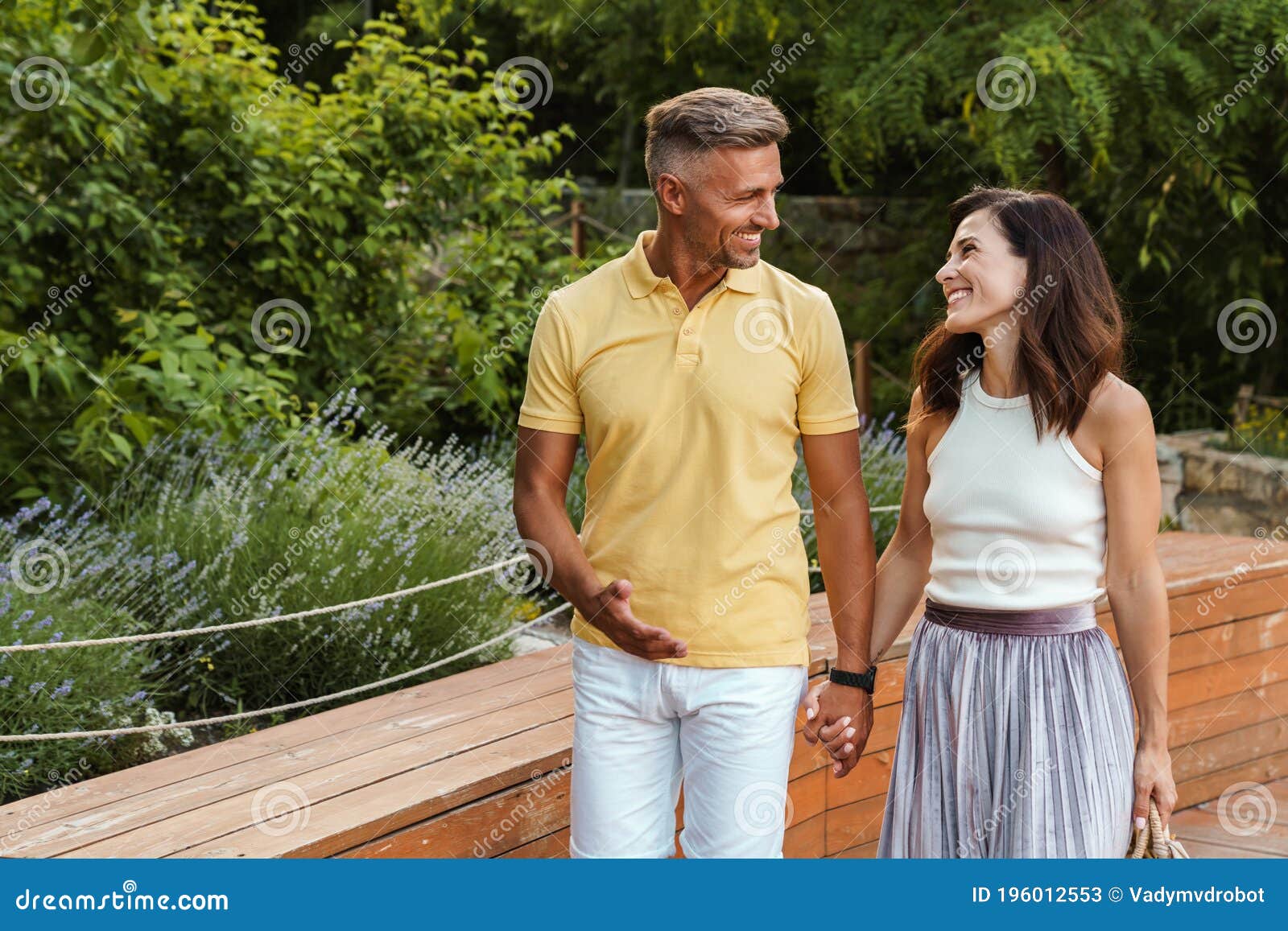 Portrait Of Smiling Middle Aged Couple Holding Hands Together While