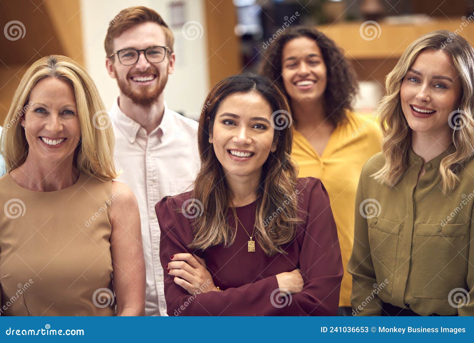 Portrait Of Smiling Multi Cultural Business Team Standing In Modern