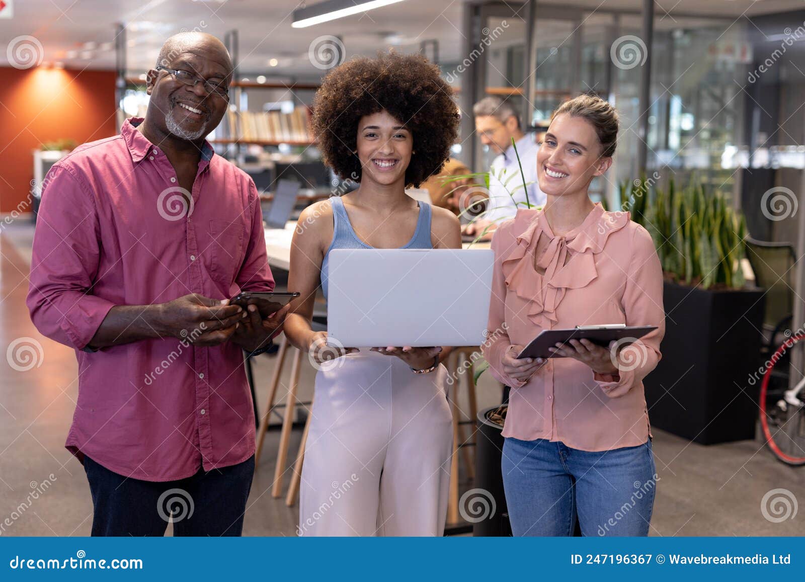 Portrait of Smiling Multiracial Colleagues Standing with Wireless ...