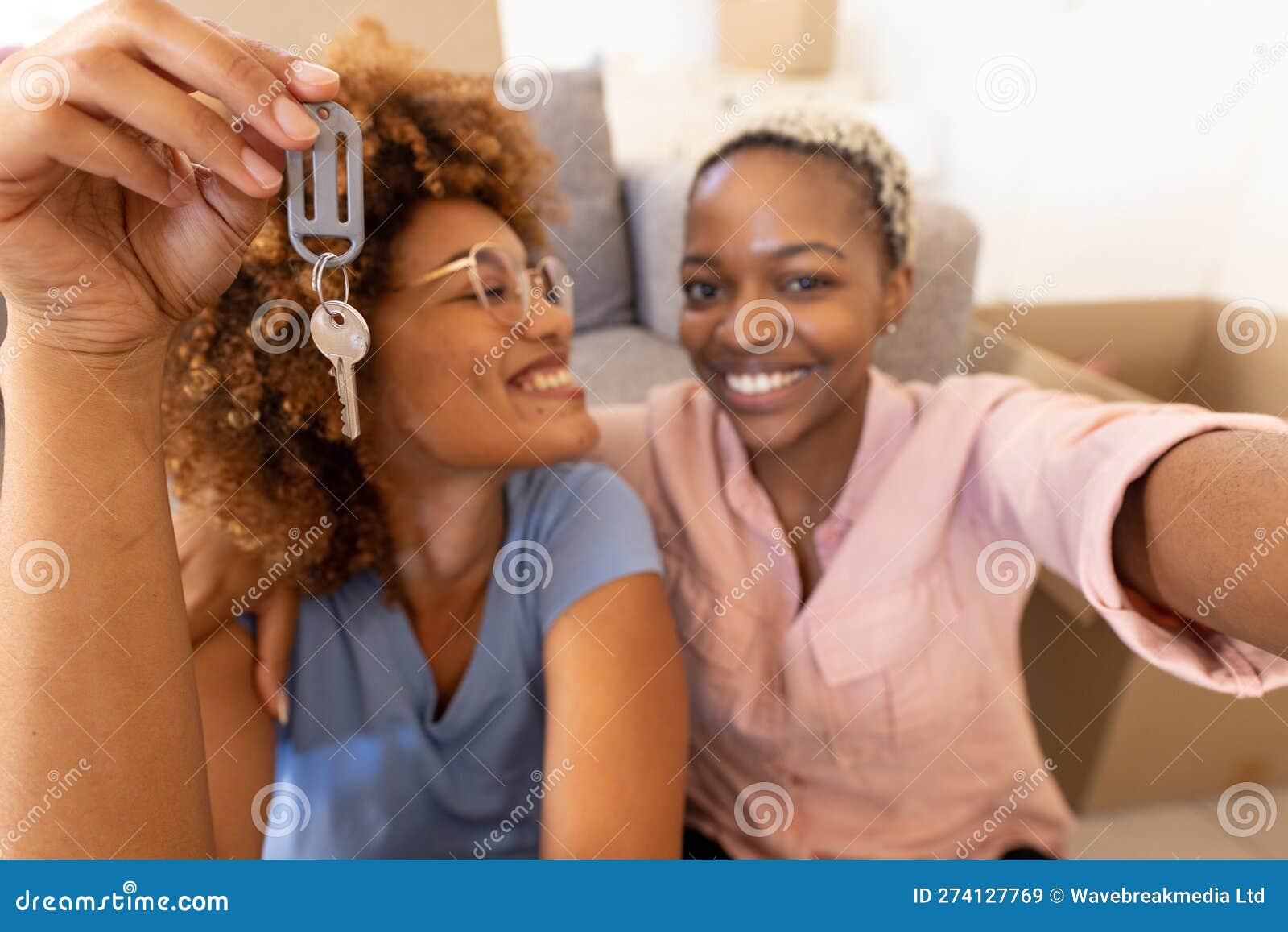 Portrait Of Smiling Multiracial Lesbian Couple Showing New House Key