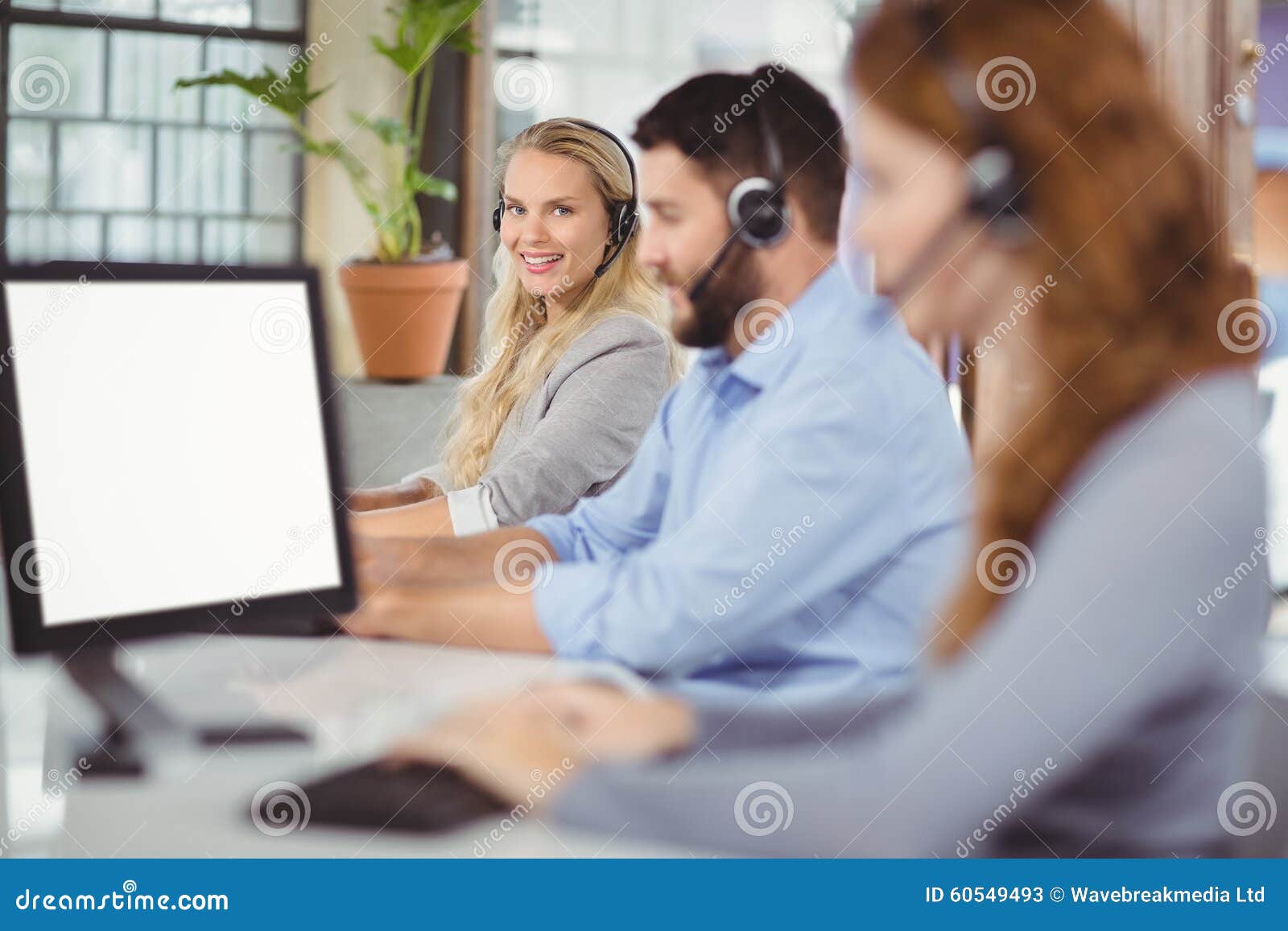 Portrait of Smiling Operator with Colleagues in Office Stock Image ...
