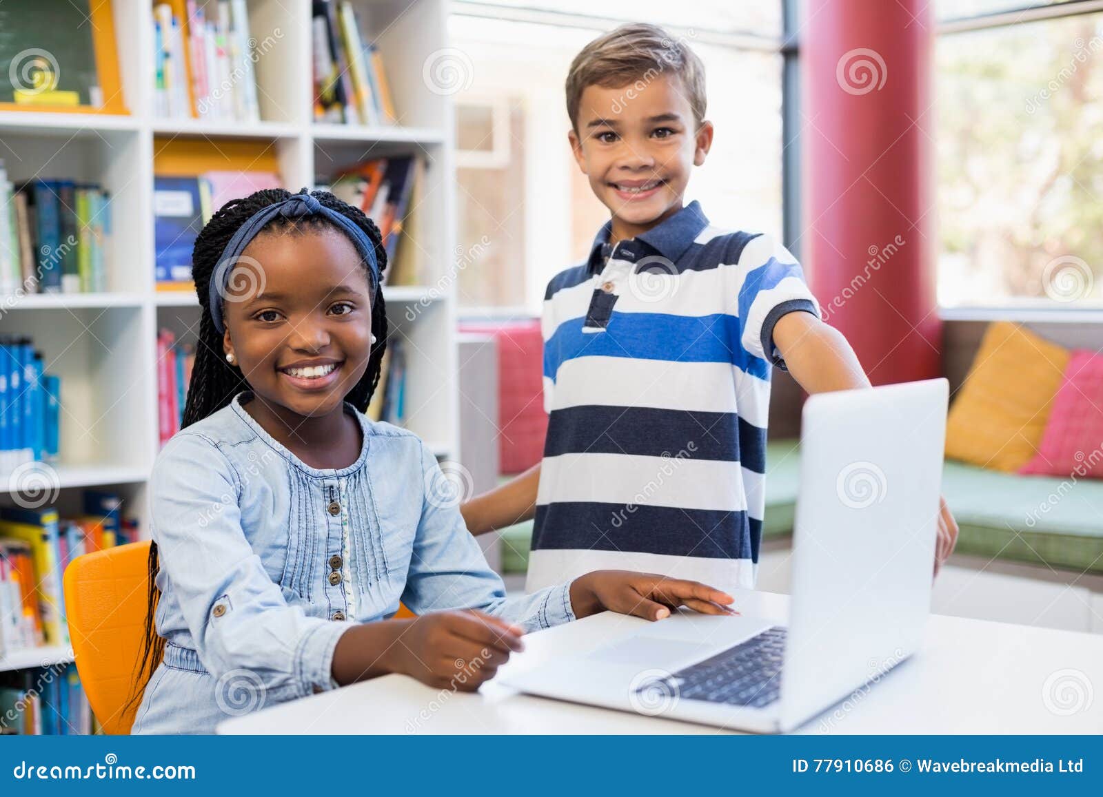 Portrait of Smiling School Kids Using a Laptop in Library Stock Photo ...