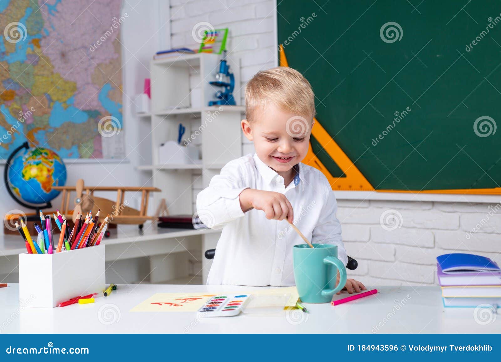 Portrait of Smiling Schoolboy Doing His Homework in Classroom at School ...