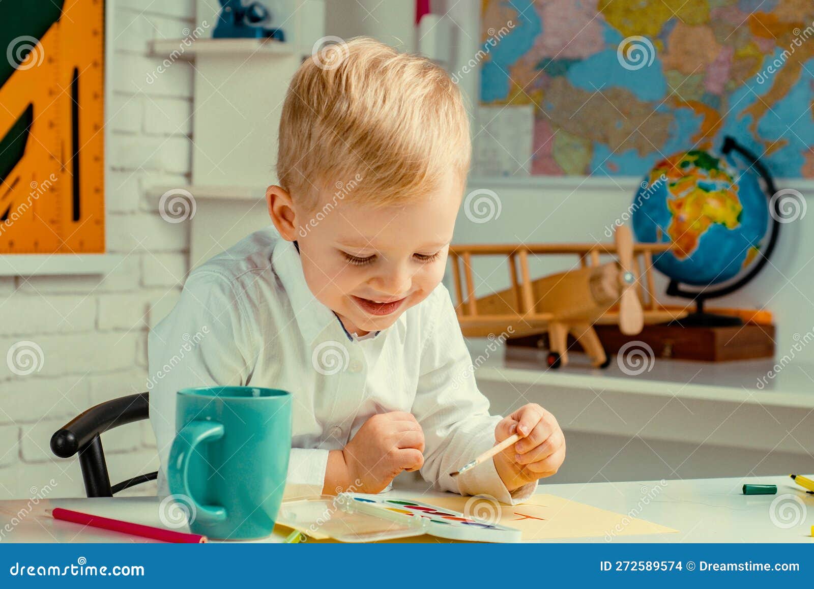 Portrait of Smiling Schoolboy Doing His Homework in Classroom at School ...