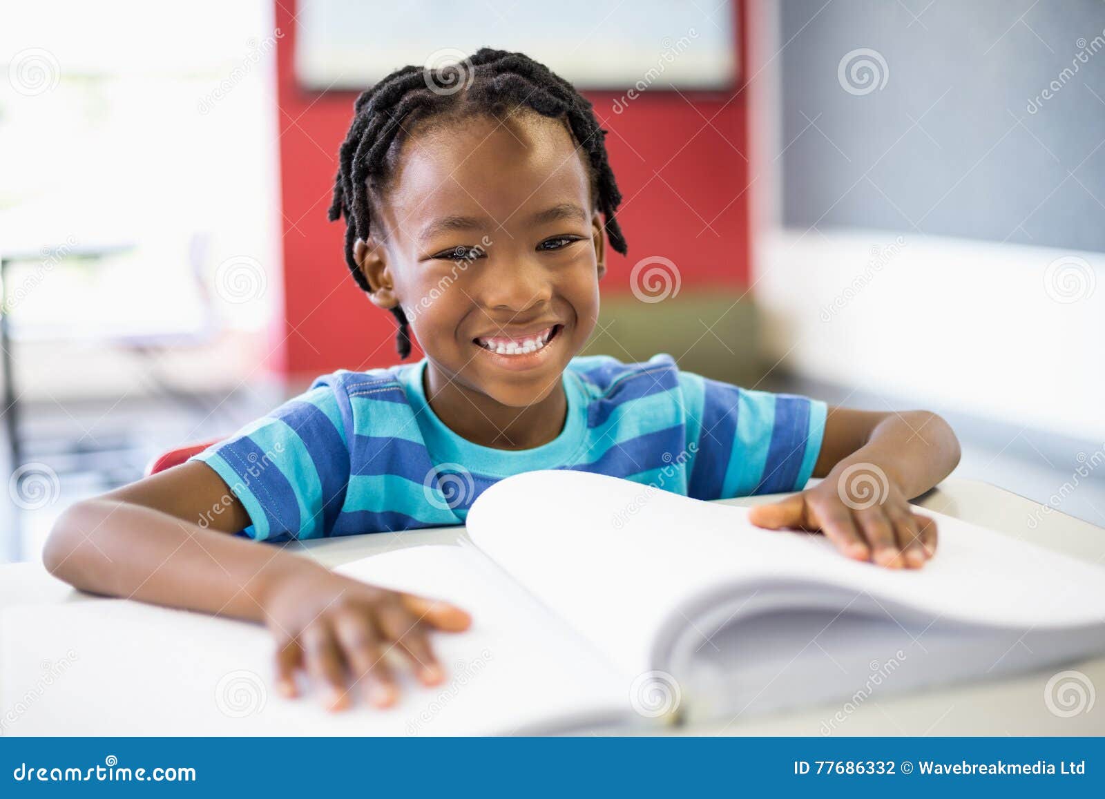 Portrait of Smiling Schoolboy Reading Book in Classroom Stock Photo ...