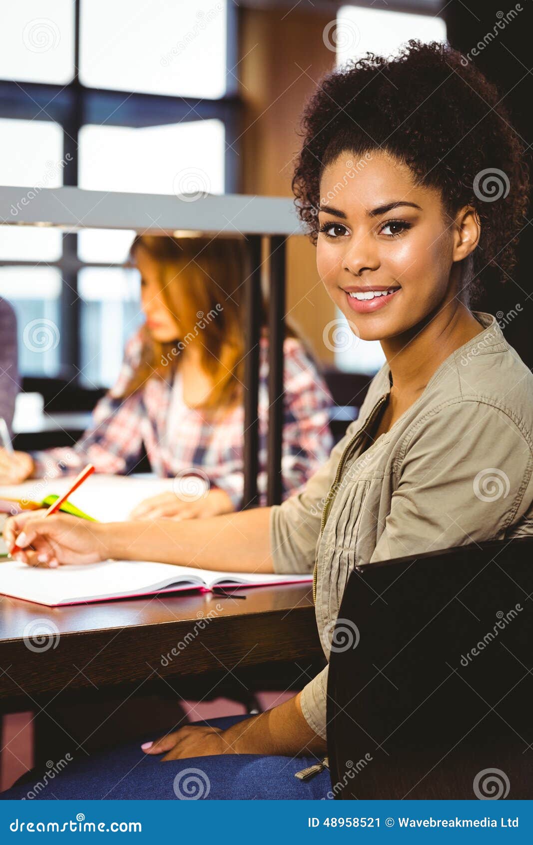 Portrait of a Smiling Student Sitting at Desk Looking at Camera Stock ...