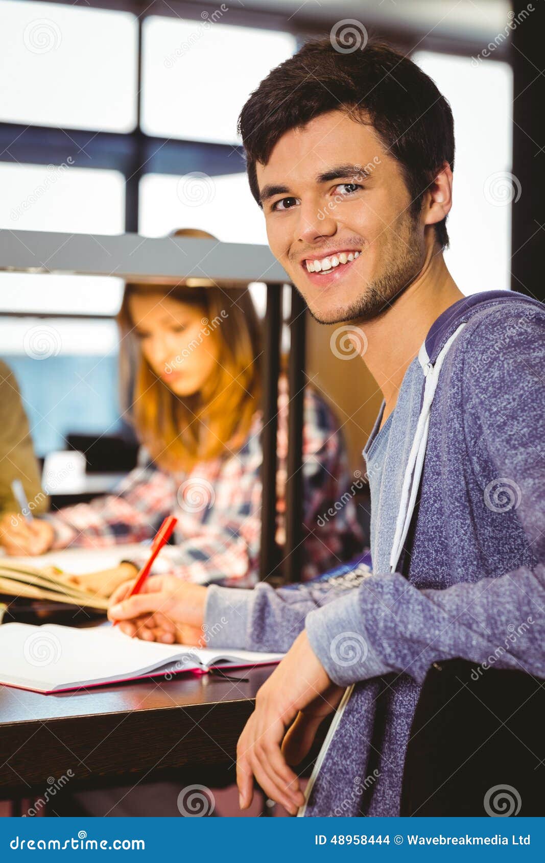 Portrait of a Smiling Student Sitting at Desk Looking at Camera Stock ...