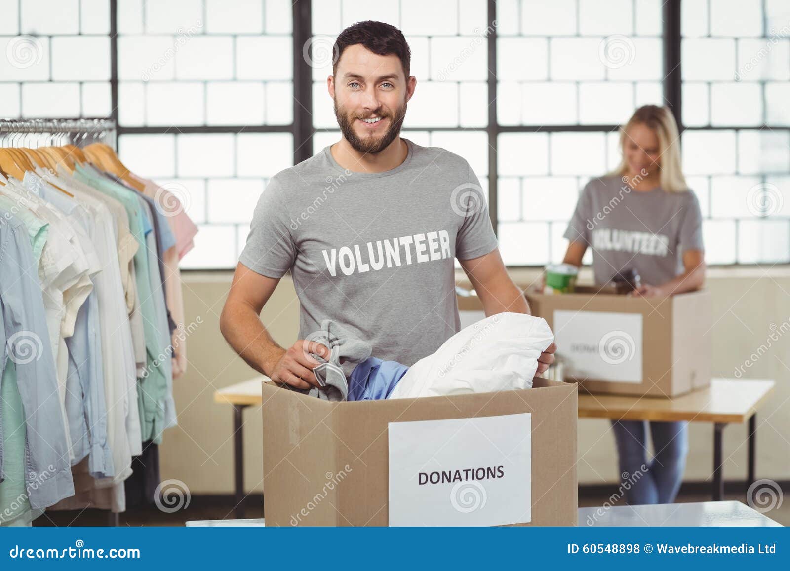 Portrait of Smiling Volunteer Separating Clothes from Donation Box ...