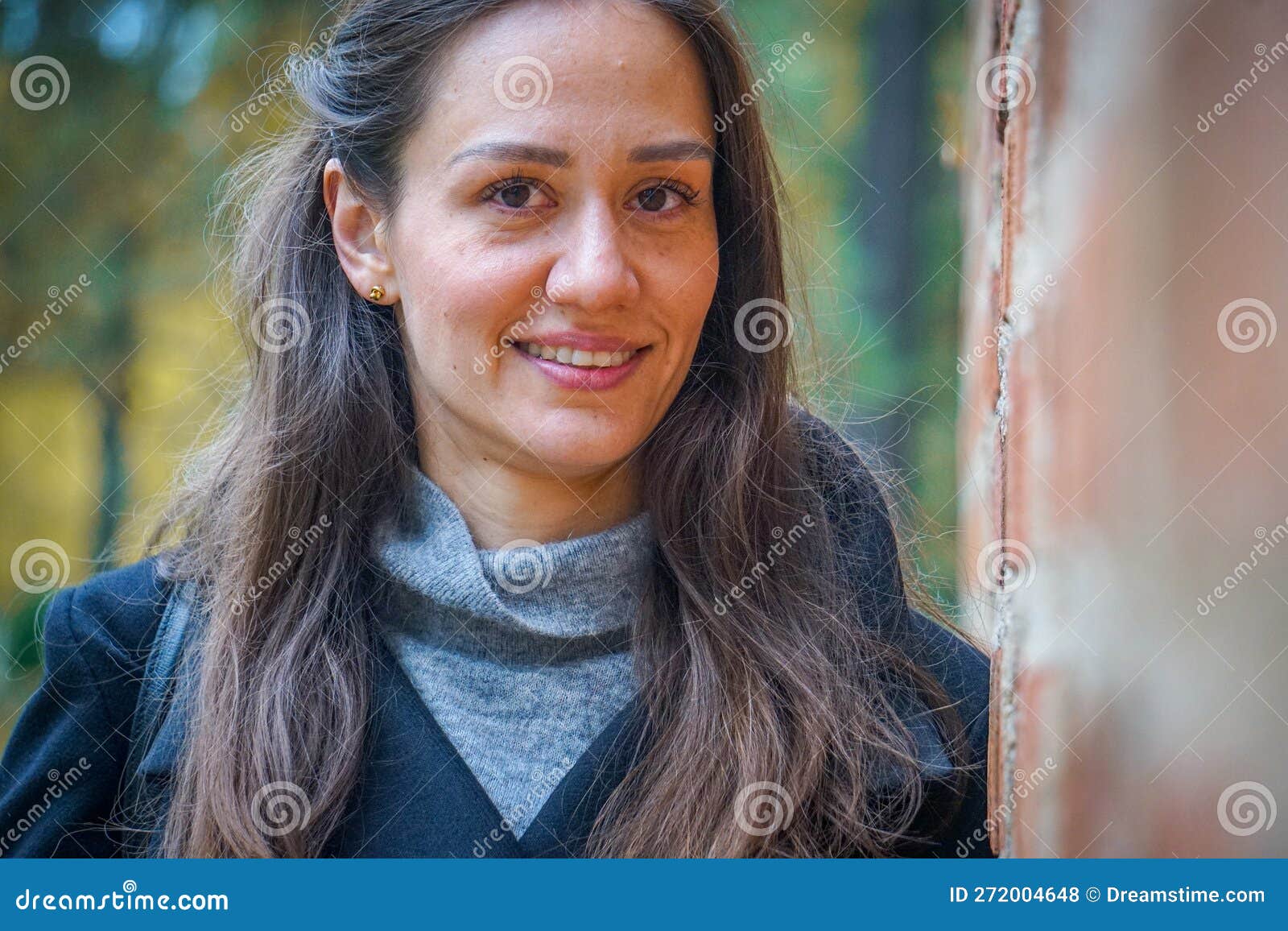 Portrait of Smiling Woman Standing Next To Brick Wall Stock Photo ...