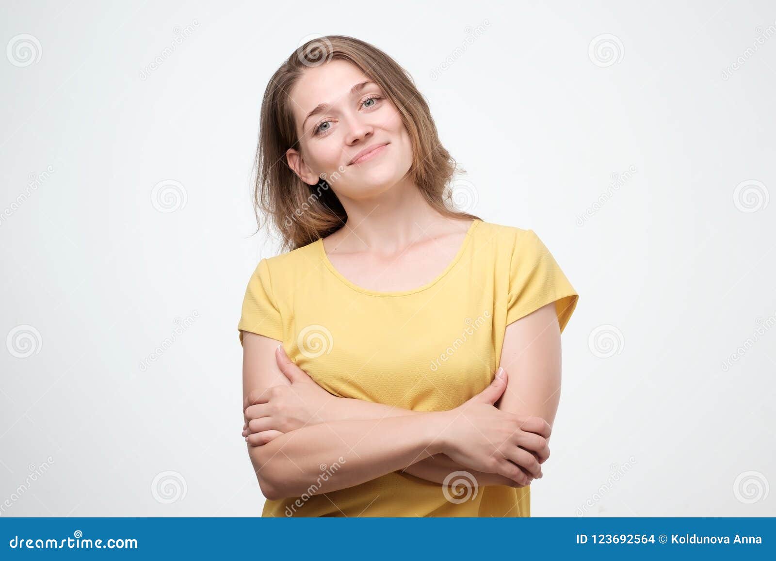 Portrait of a Smiling Young European Woman Standing with Arms Folded ... Portrait of a Smiling Young European Woman Standing with Arms Folded ...