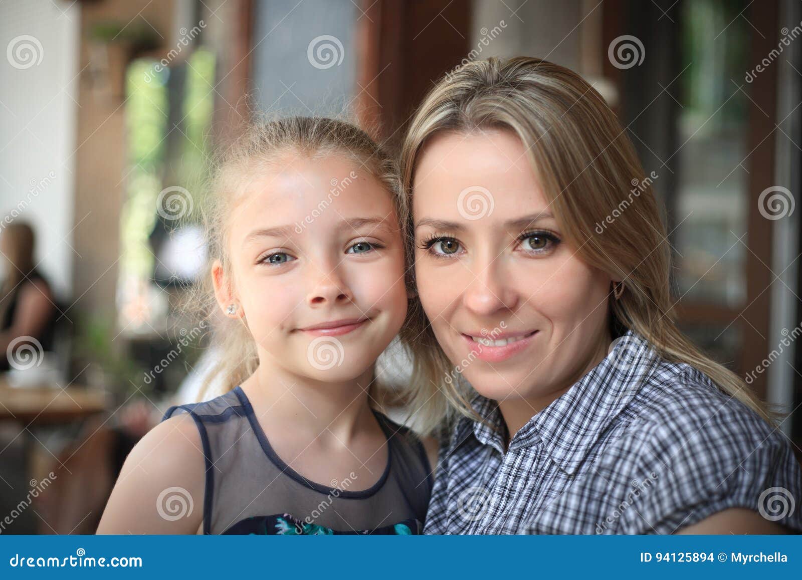 Portrait Of A Smiling Young Mother And Daughter Close Up Outdoors