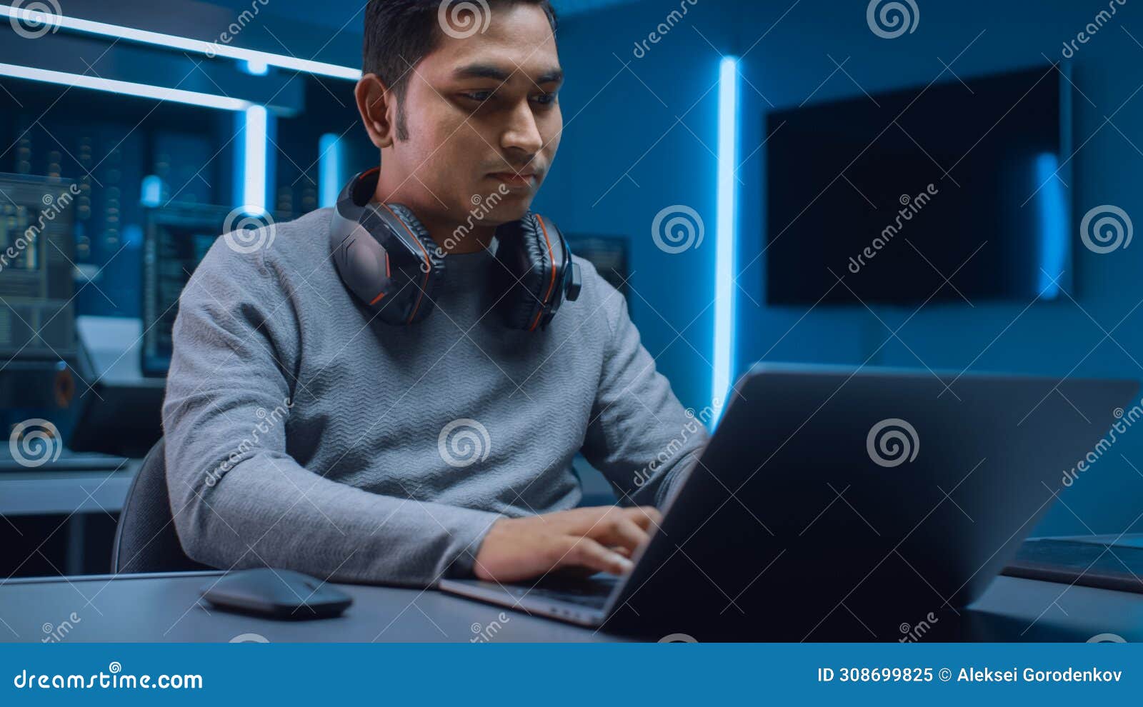 Portrait Of Software Developer Hacker Programmer Sitting At His Desk And Working On Laptop