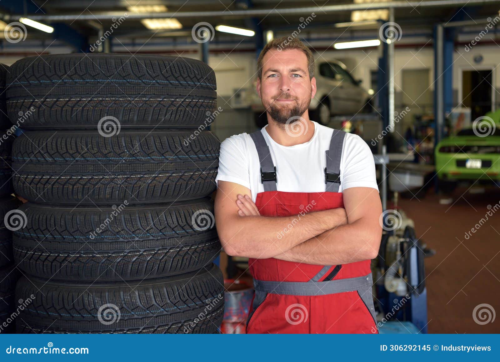 Portrait of Successful Smiling Car Mechanic in a Workshop on a Stack of ...