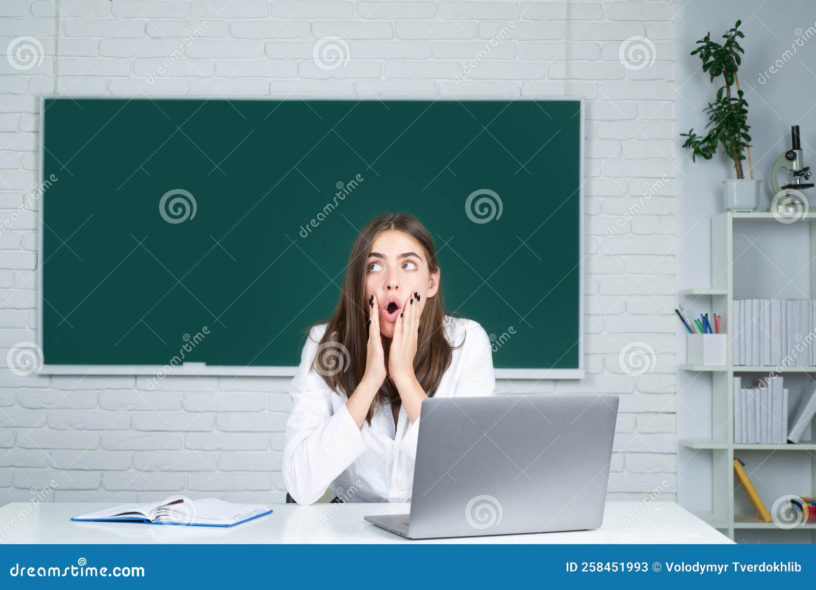 Portrait of a Surprised Female Student Studying in School Classroom ...