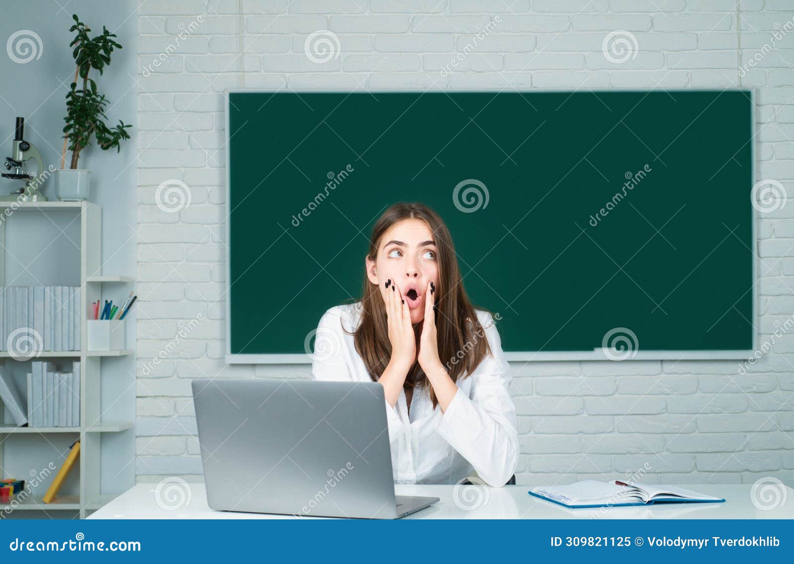 Portrait of a Surprised Female Student Studying in School Classroom ...