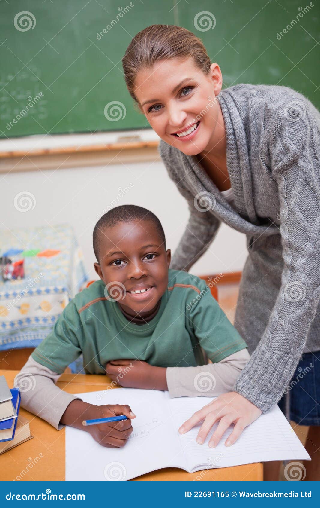 Portrait of a Teacher Explaining Something To a Smiling Schoolbo Stock ...