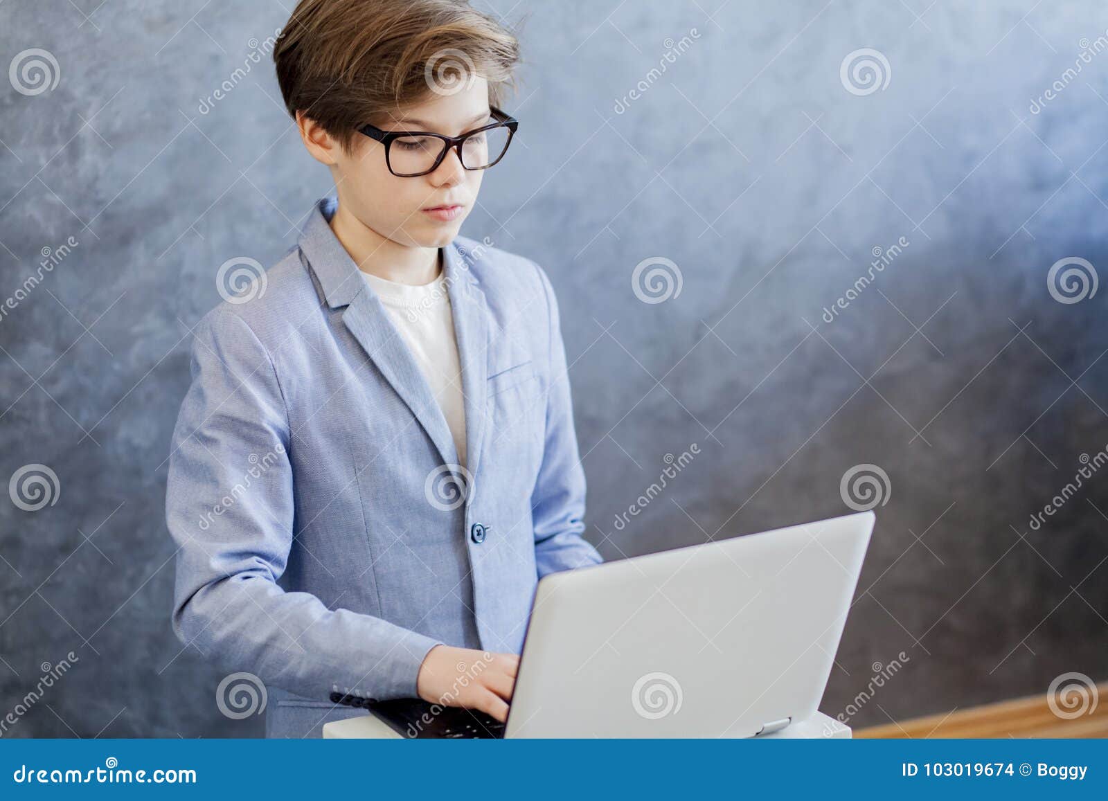 Teen boy using laptop stock photo. Image of sitting - 103019674
