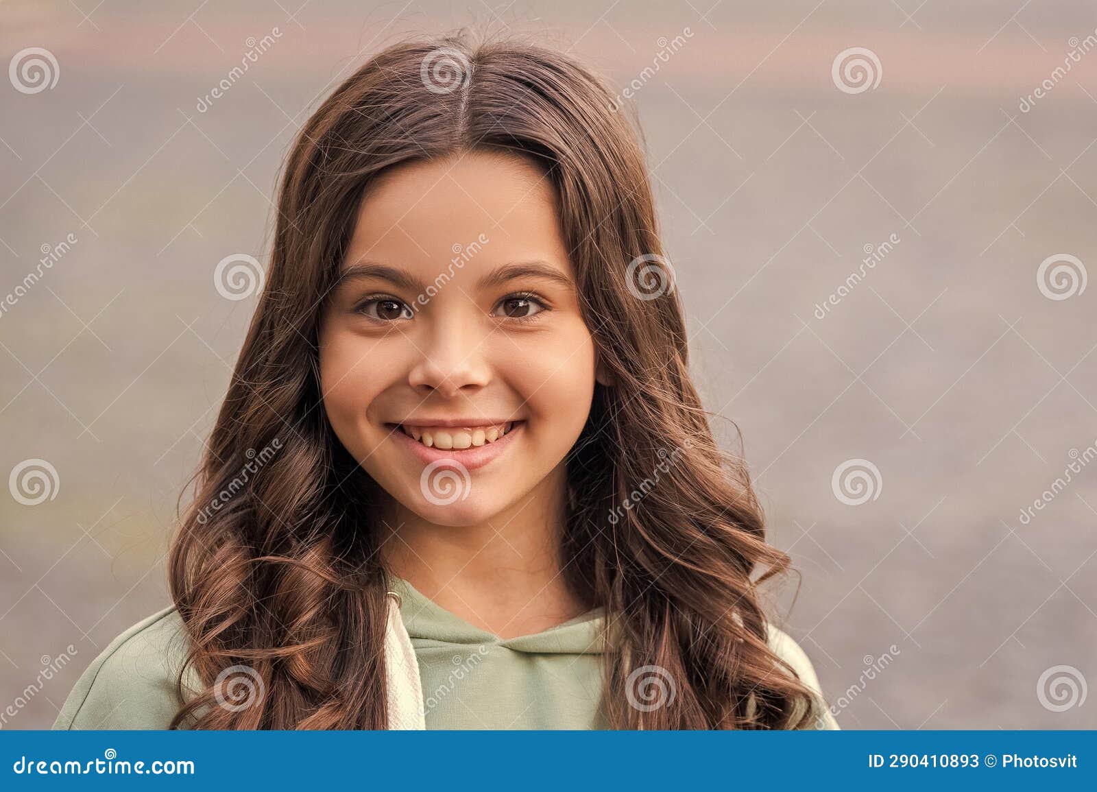 Portrait Of Teen Girl With Smiling Face And Long Curly Hair Blurry