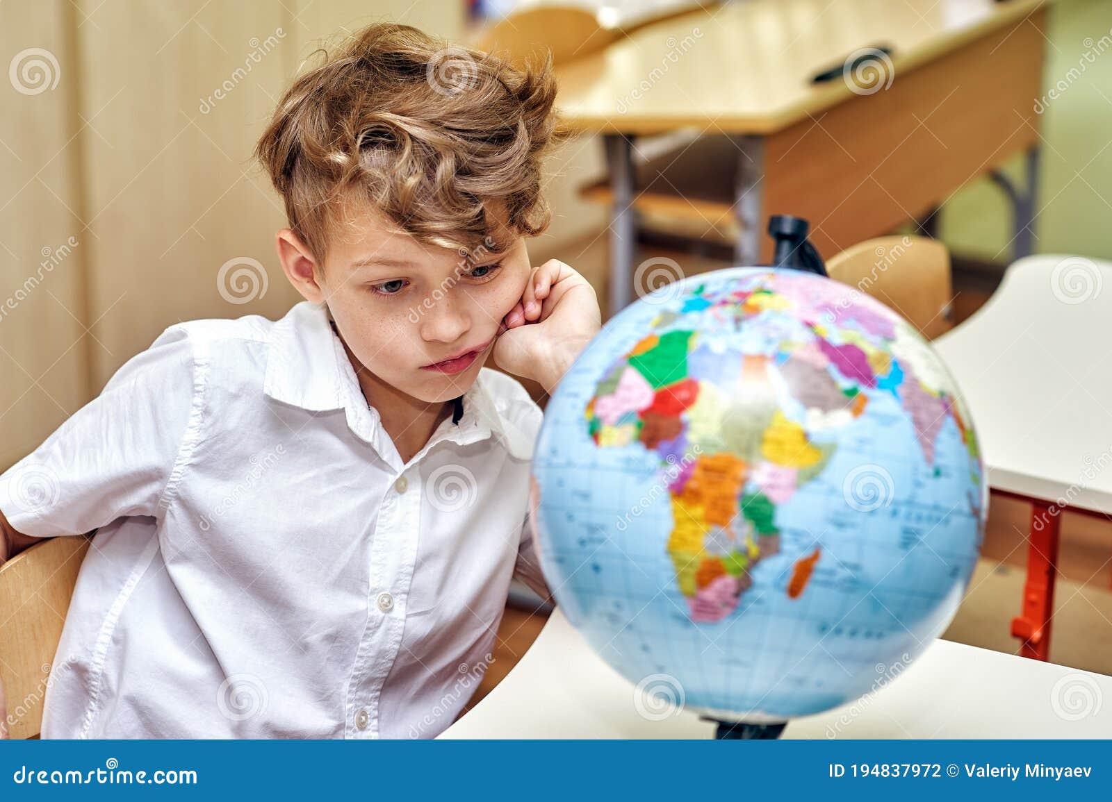 Portrait of a Thoughtful Elementary School Student with a Globe Stock ...