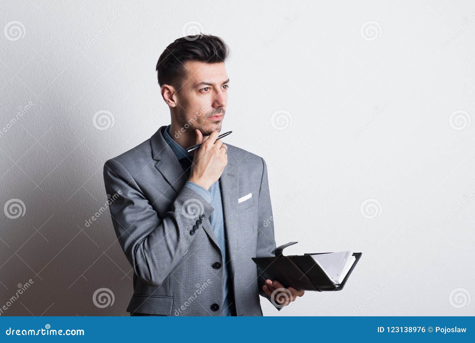 Portrait of a Thoughtful Young Man with a Pen and a Diary in a Studio ... Portrait of a Thoughtful Young Man with a Pen and a Diary in a Studio ...