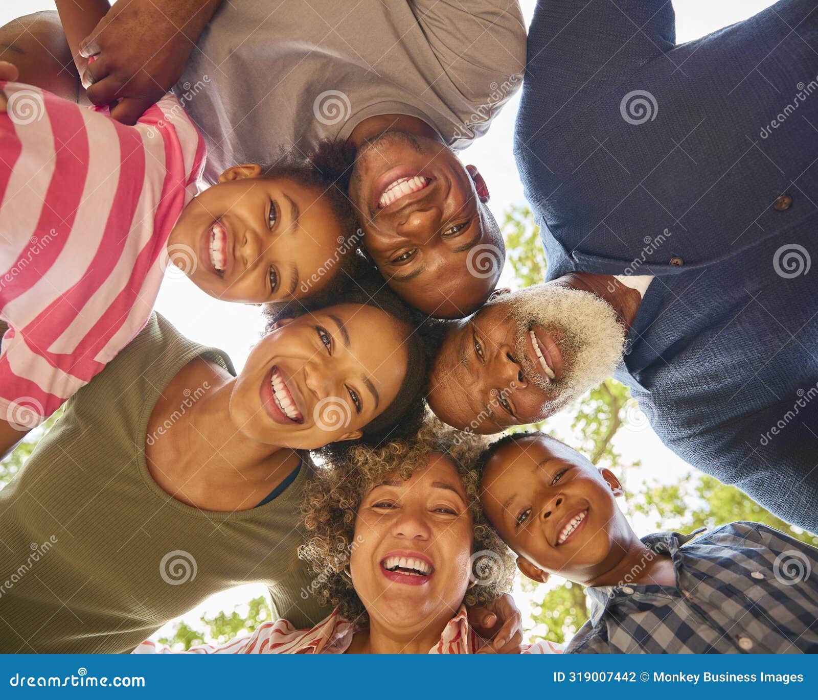 Portrait of Three Generation Family Outdoors Looking Down into Camera ...