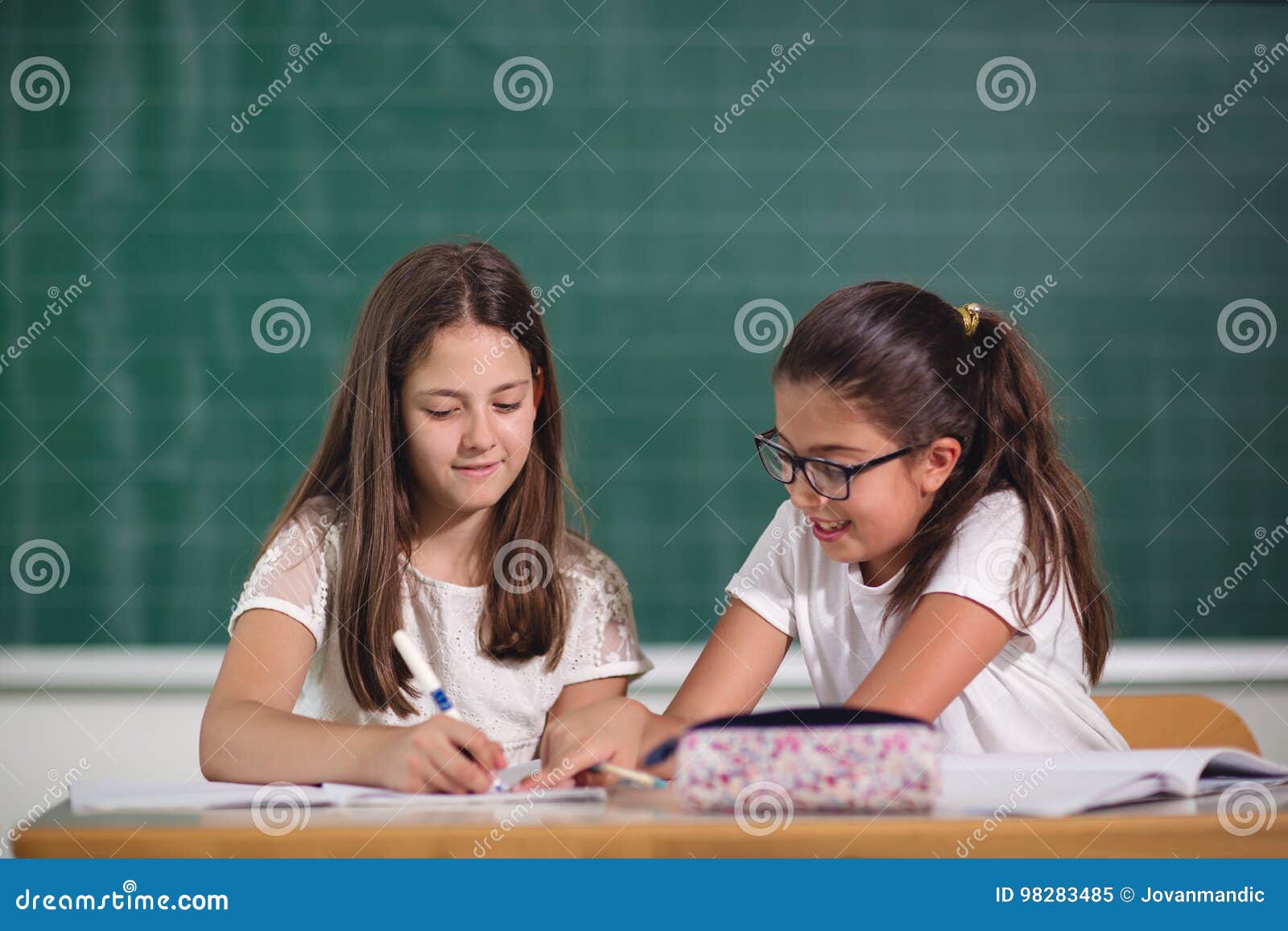 Portrait Of Schoolgirls Standing With Classmate With Classmates In ...