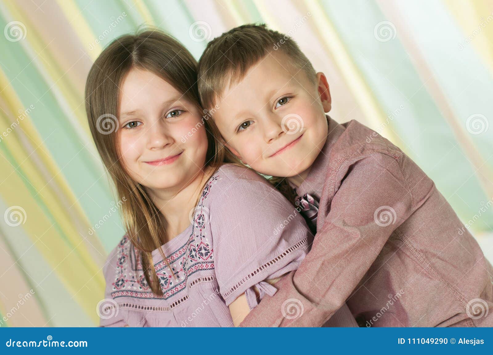 Portrait of the Two Hugging Siblings Over Stripped Green-yellow ...