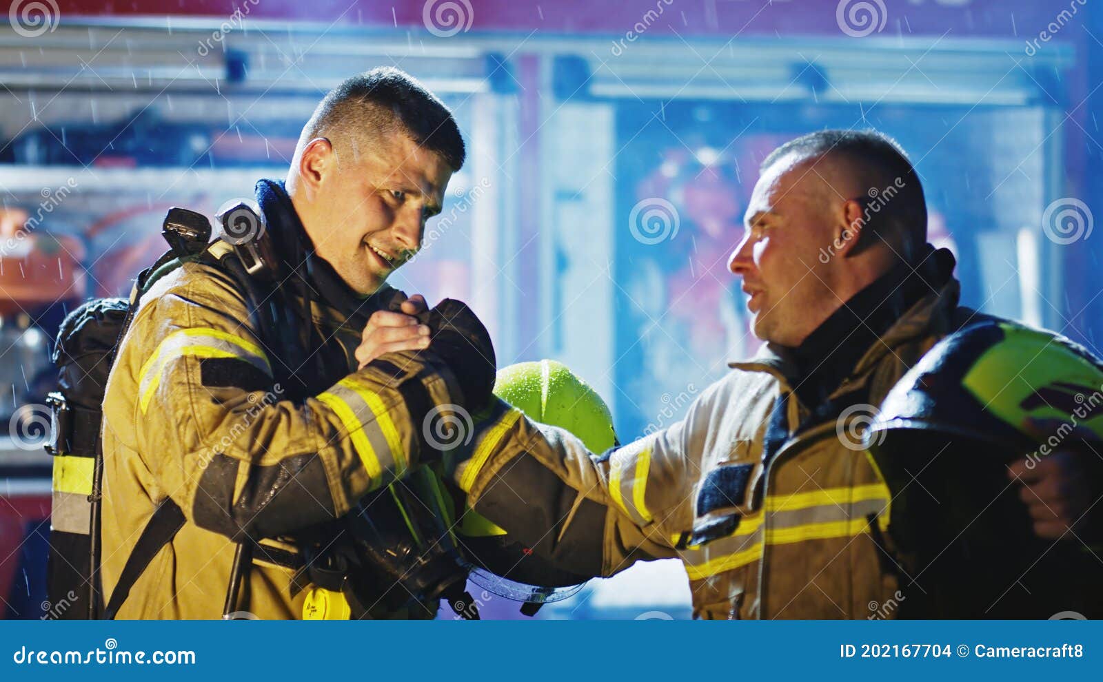 Portrait of Two Young Firefighters on the Rain in Front of Fire Engine ...