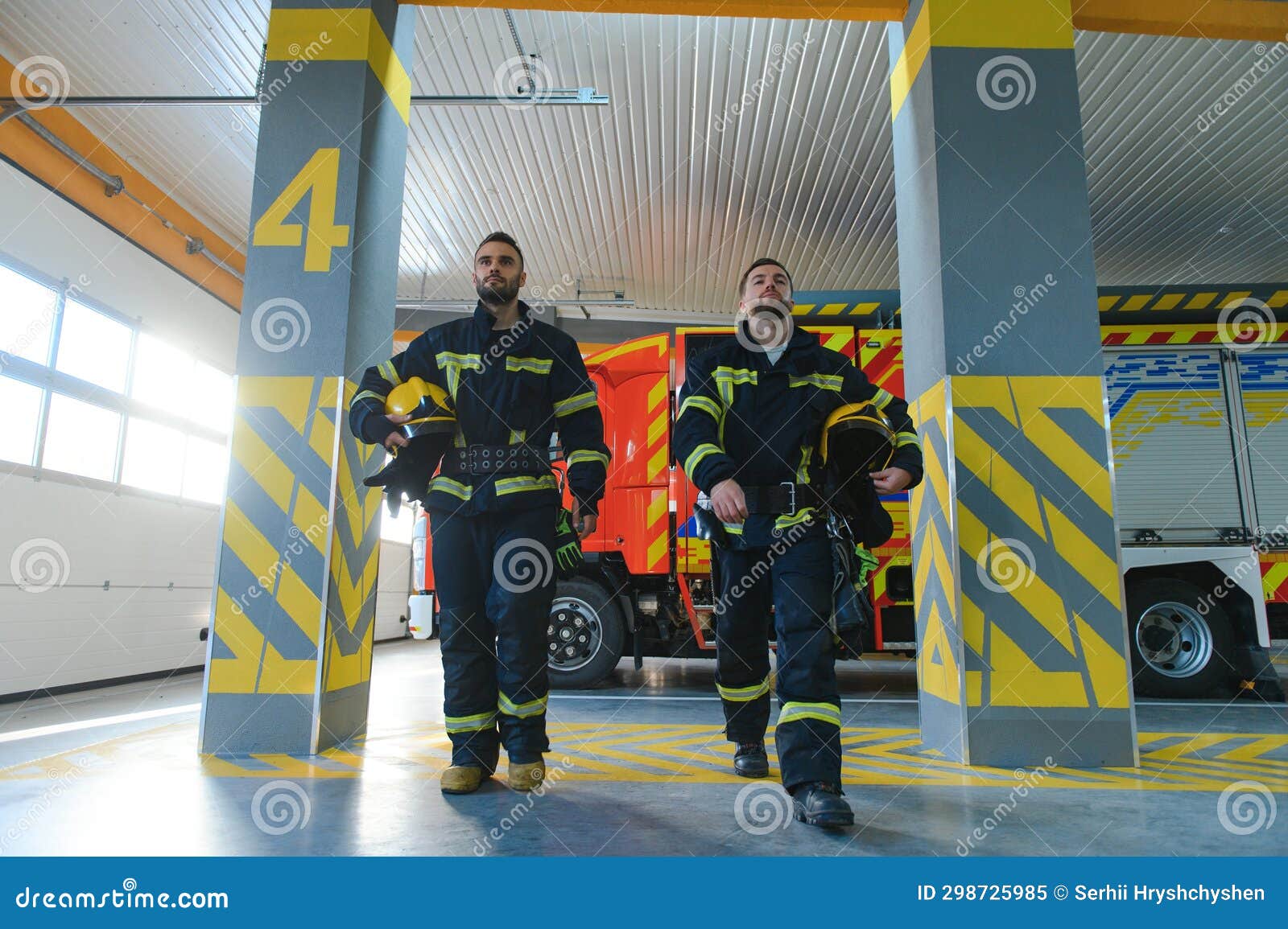 Portrait of Two Young Firemen in Uniform Standing Inside the Fire ...