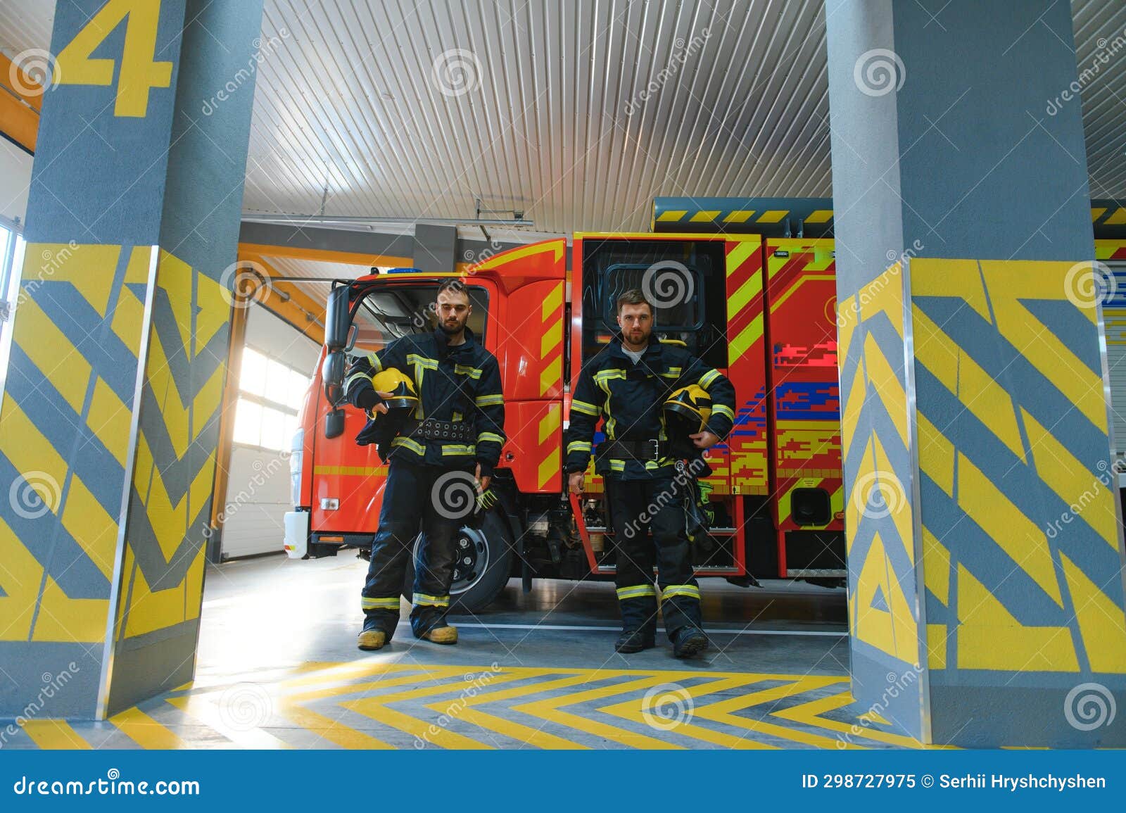 Portrait of Two Young Firemen in Uniform Standing Inside the Fire ...
