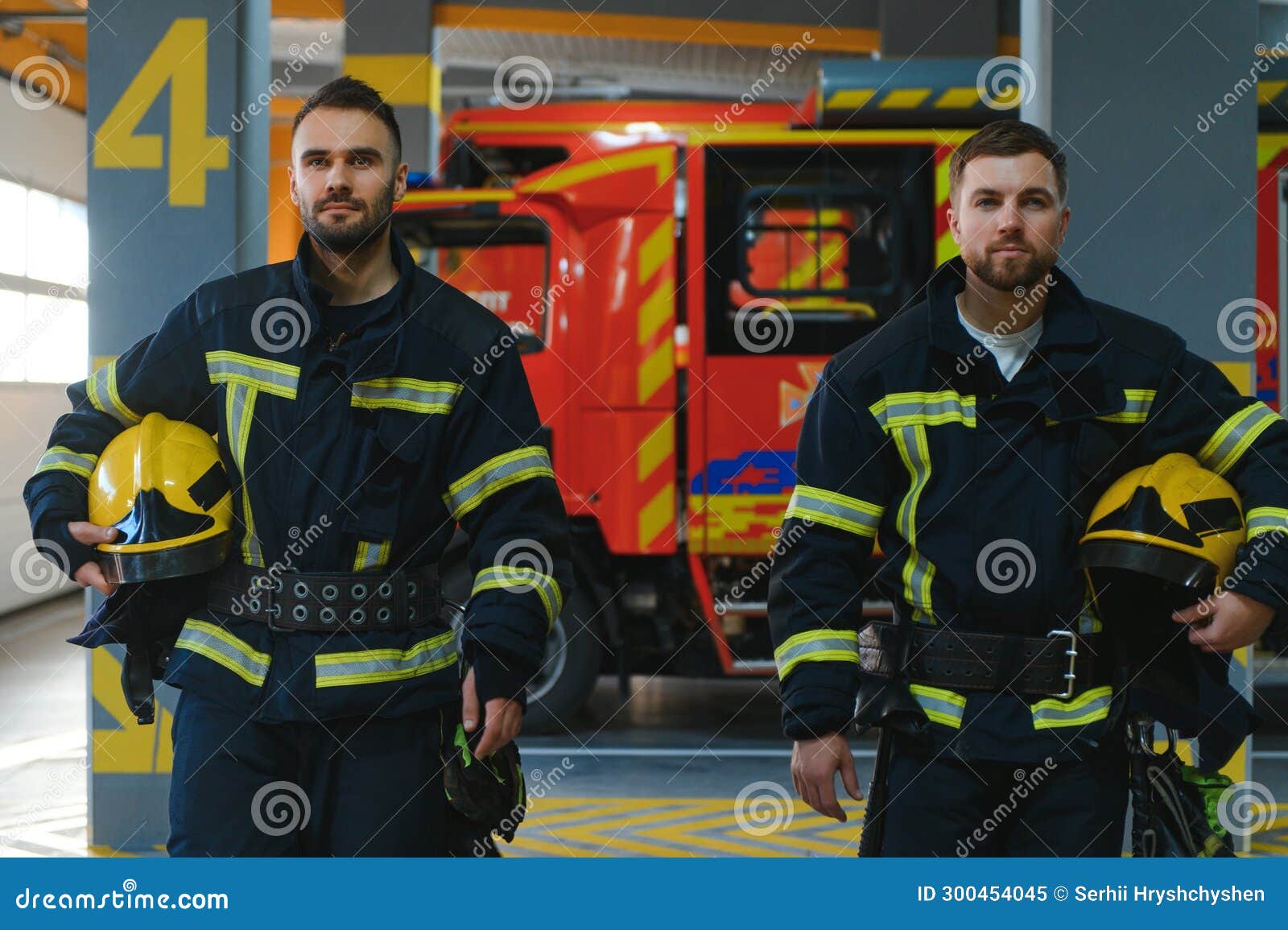 Portrait of Two Young Firemen in Uniform Standing Inside the Fire ...