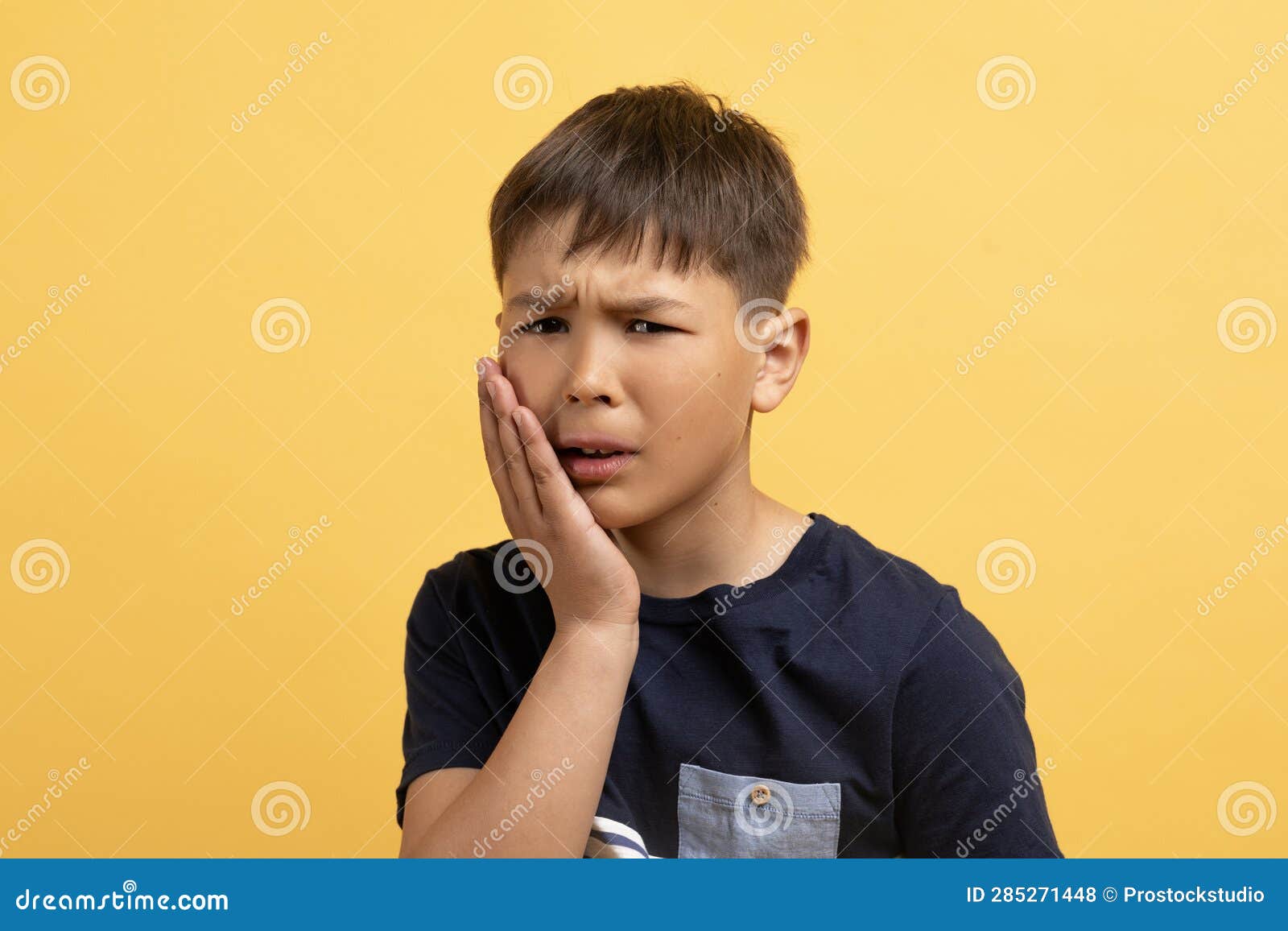 Portrait of Unhealthy School Aged Boy Touching Cheek Stock Photo ...