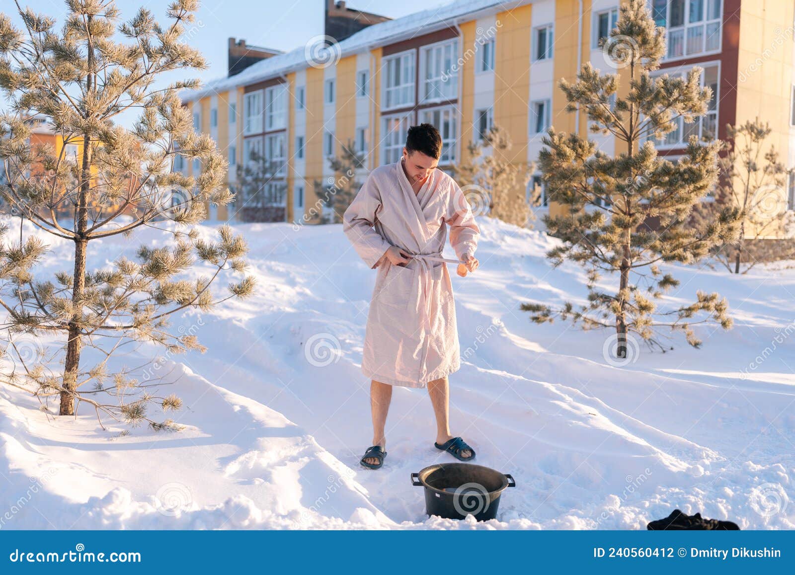 Portrait Of Willed Young Man Taking Off Robe Getting Ready For Hardening Procedure Outside