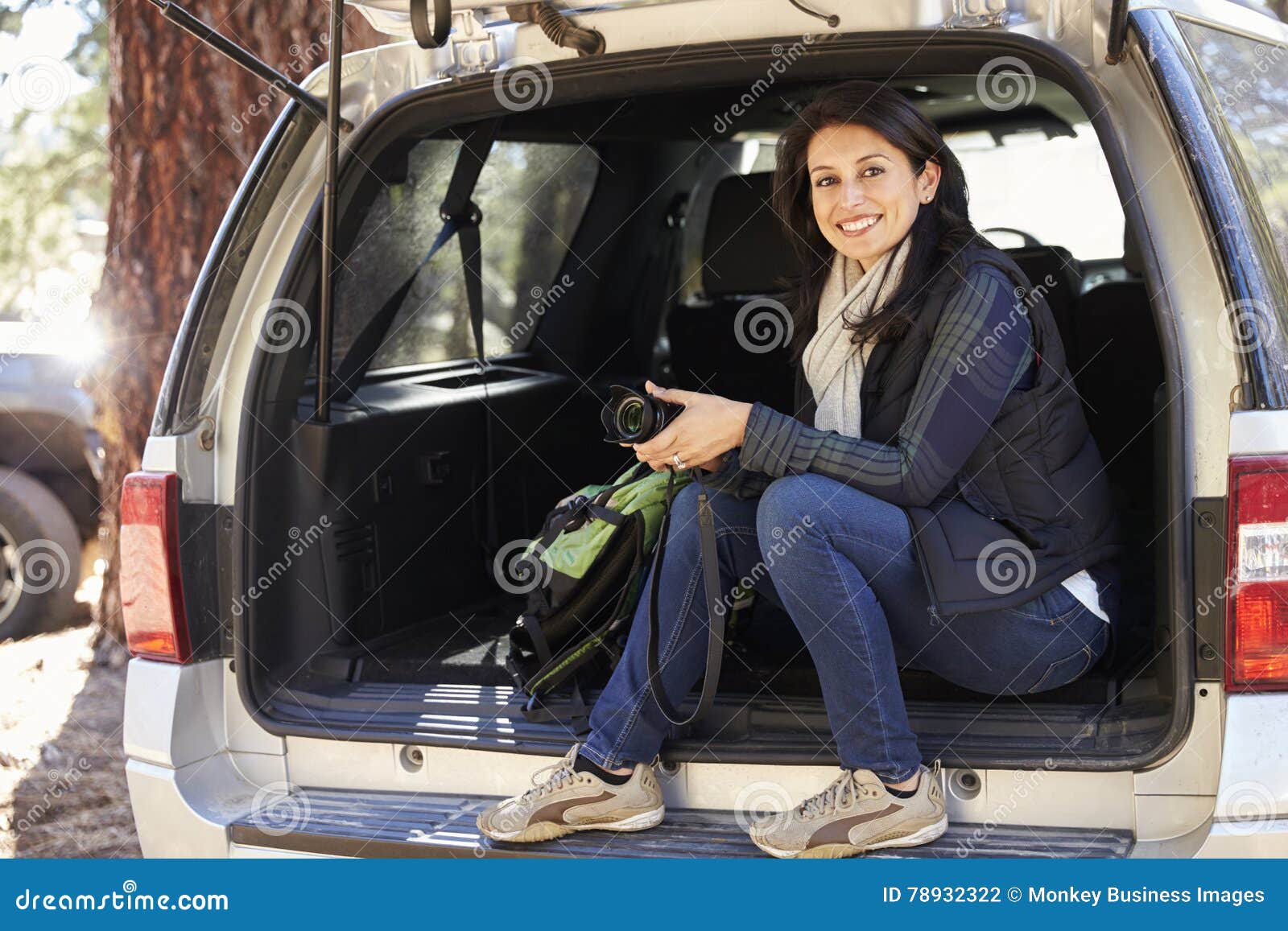 Portrait of Woman Holding Camera in the Open Back of a Car Stock Photo ...