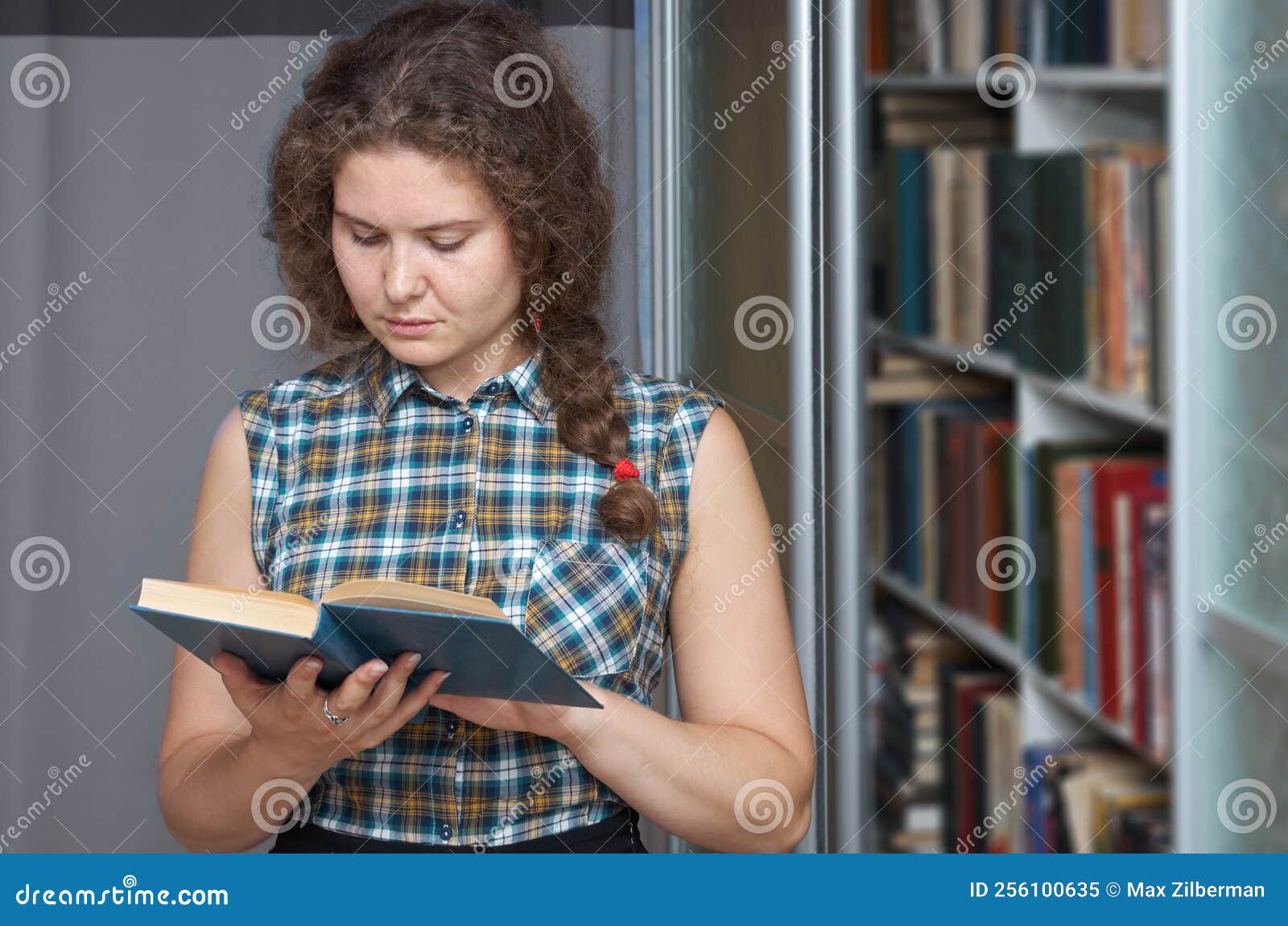 Portrait of Woman Reading a Book in Front of a Bookcase Stock Image ...
