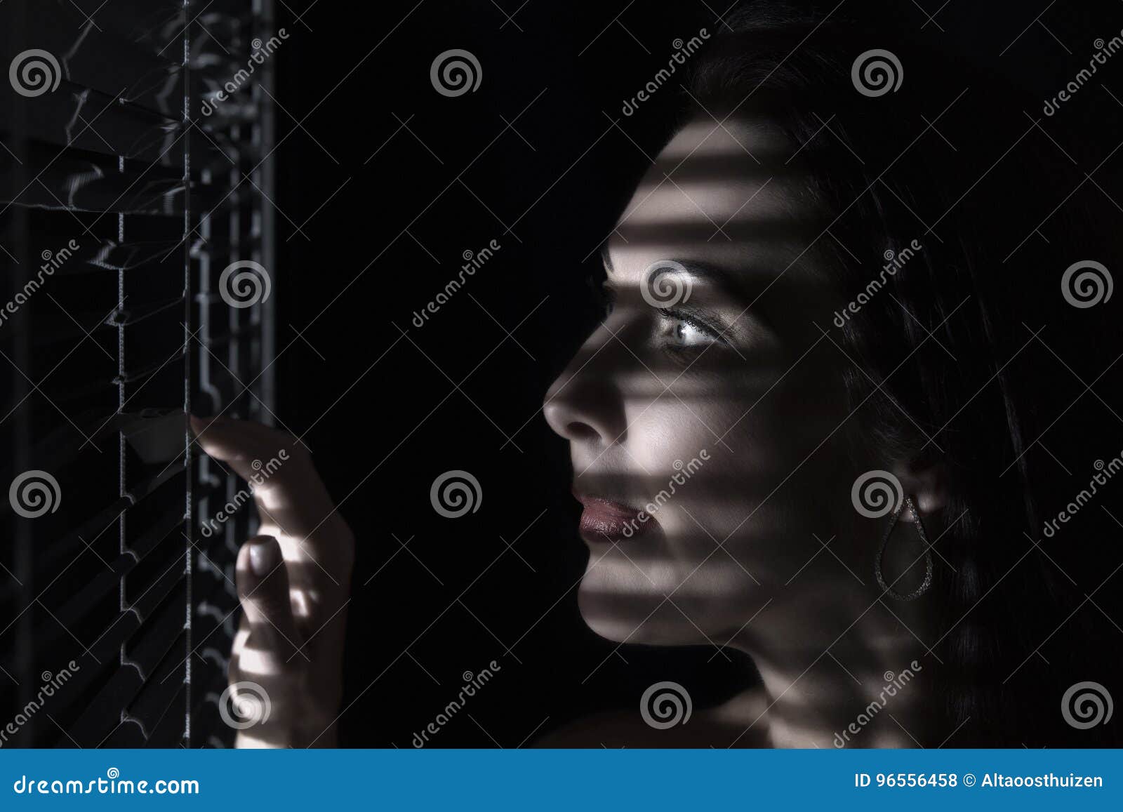 Portrait of a Woman Standing in Darkness Looking through Blinds Stock ...