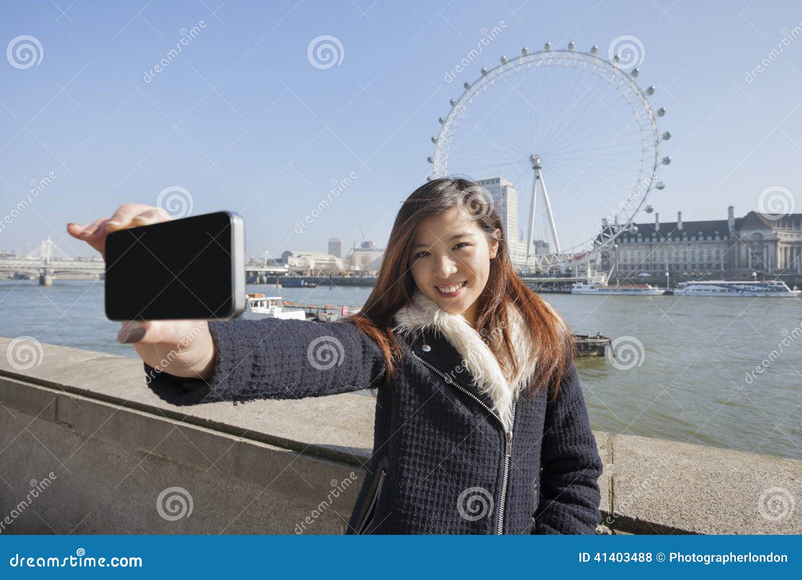 Portrait Woman Taking Self Portrait Through Cell Phone Against London