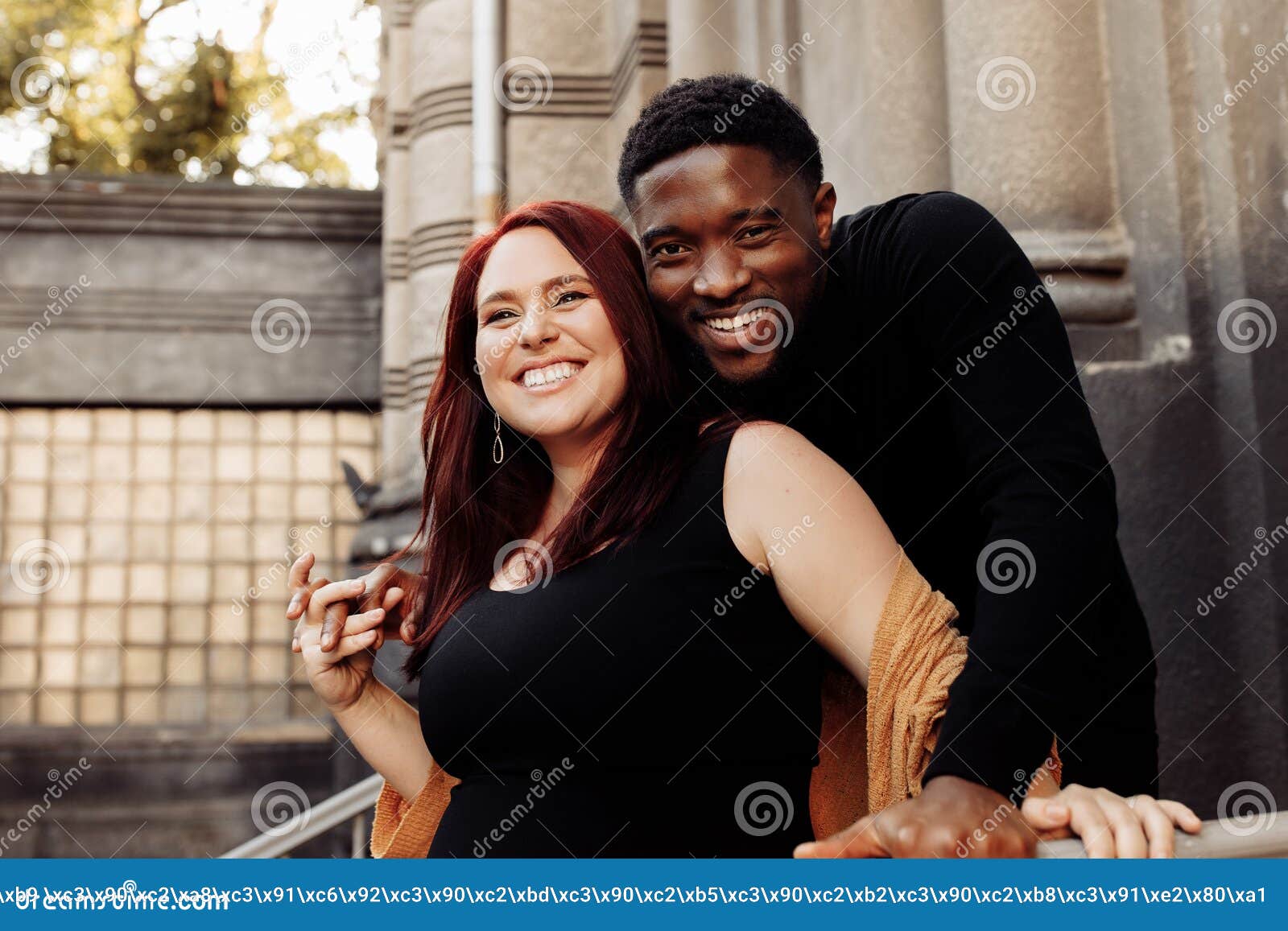 Portrait Of Wonderful Couple Cuddling Near The House At The City