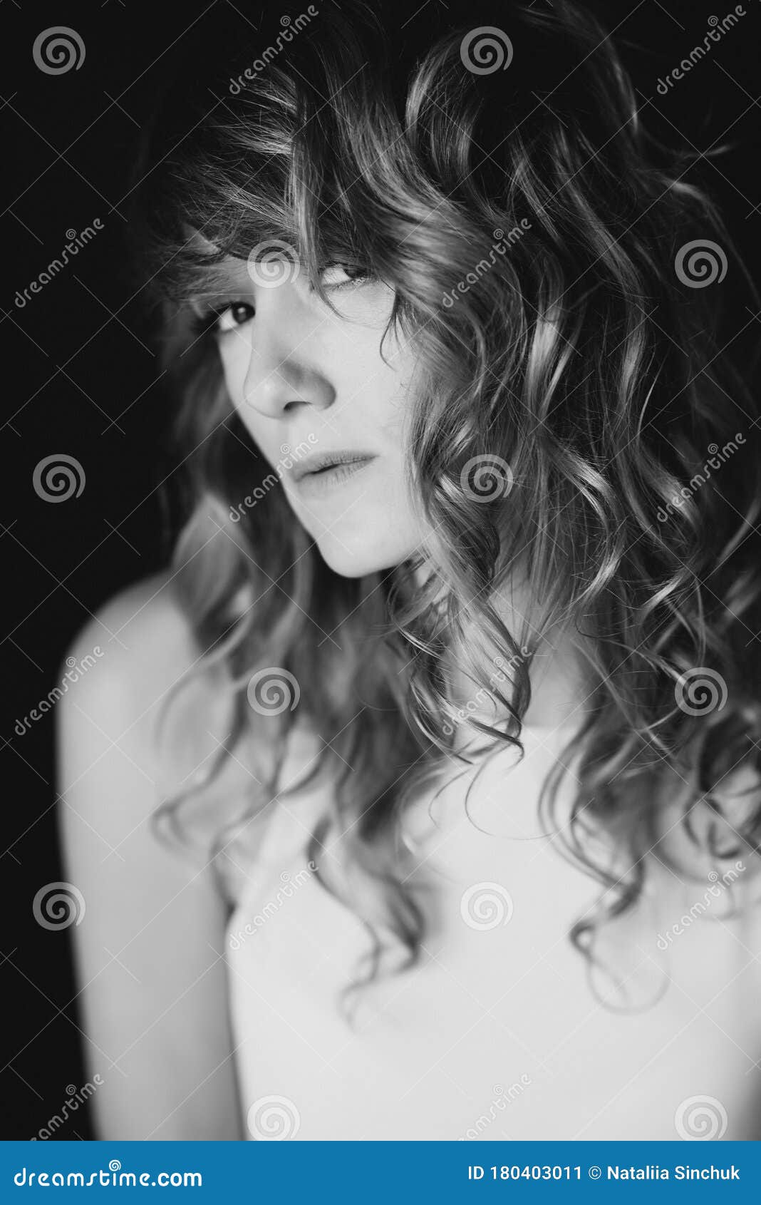 Portrait Of A 36 Year Old Woman With Curly Hair And Brown Slanting Eyes