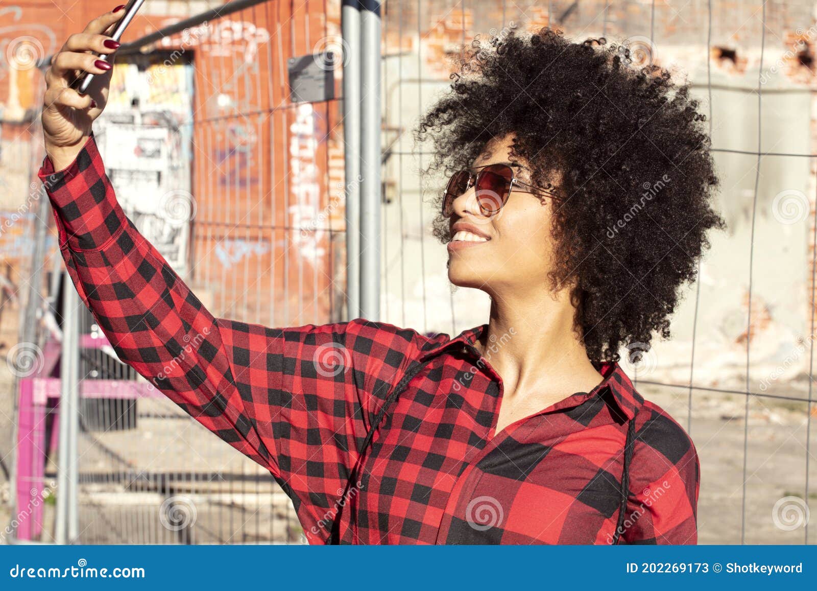 Portrait Of Young Afro Smiling Woman Taking Selfies With Her Mophile