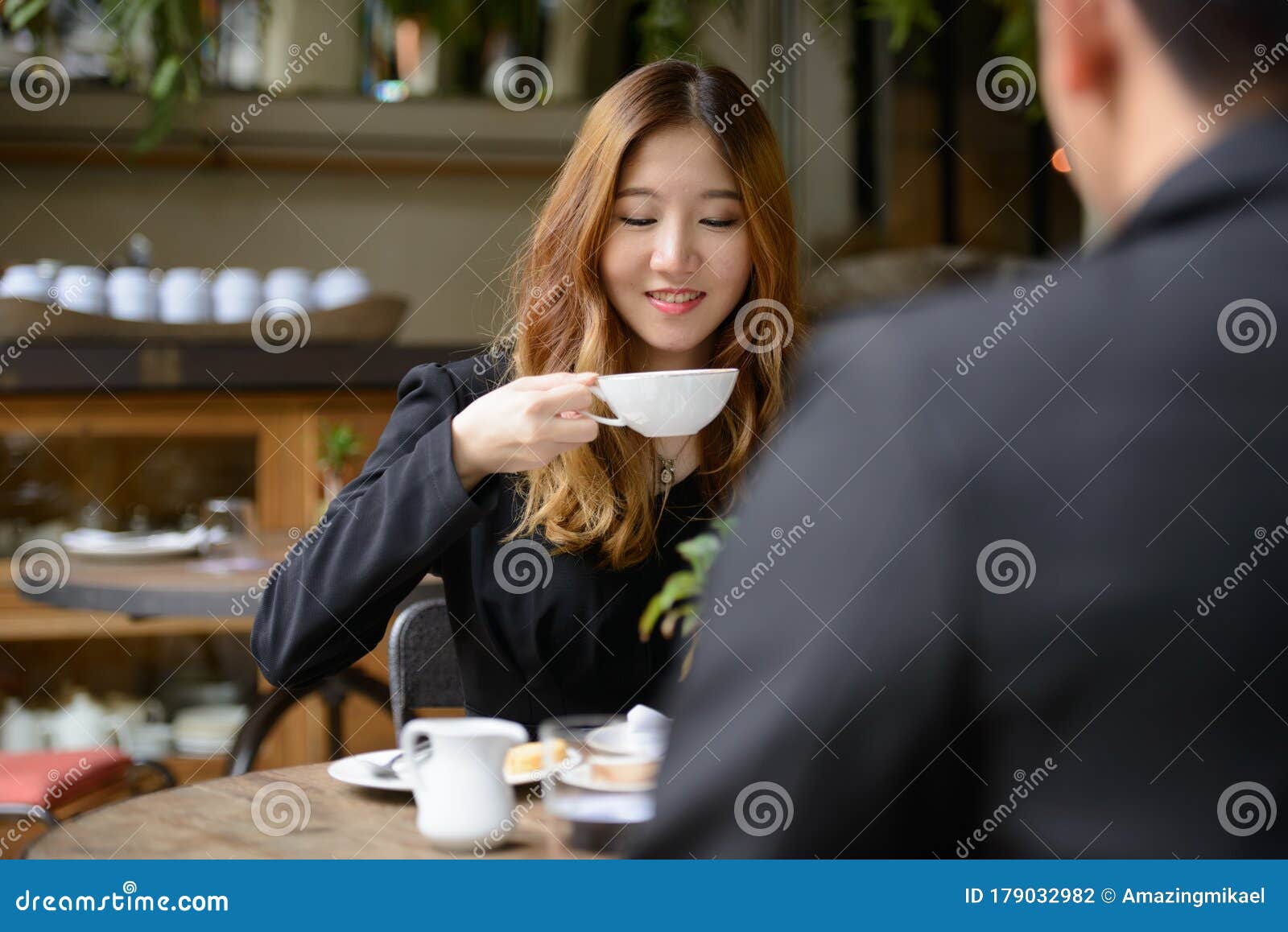 Happy Young Asian Business Couple Drinking Coffee Together at the ... Happy Young Asian Business Couple Drinking Coffee Together at the ...