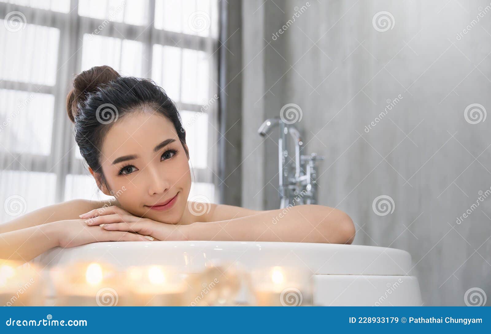 Portrait Of Young Attractive Asian Girl Takes A Bath With Candles Relax