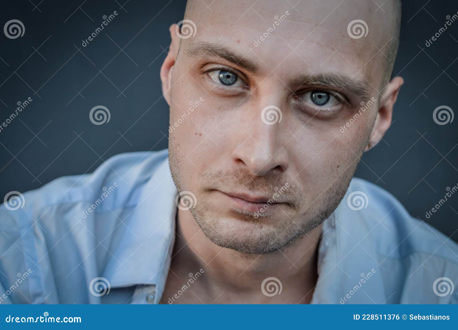 Portrait of a Young Bald Man with a Grumpy Look Staring in Front of Him ...
