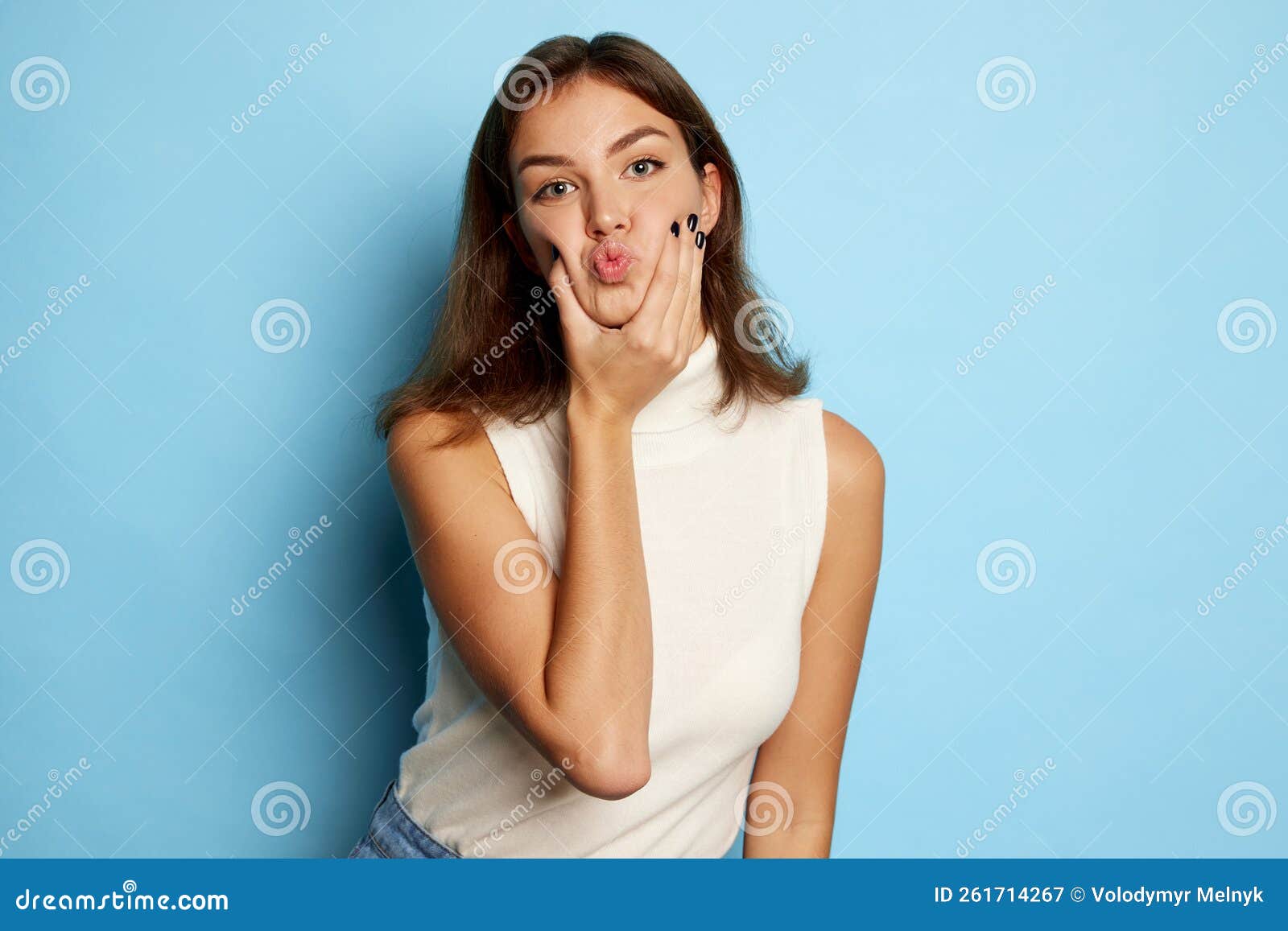 Portrait of Young Beautiful Woman Posing, Grimacing Isolated Over Blue ... Portrait of Young Beautiful Woman Posing, Grimacing Isolated Over Blue ...