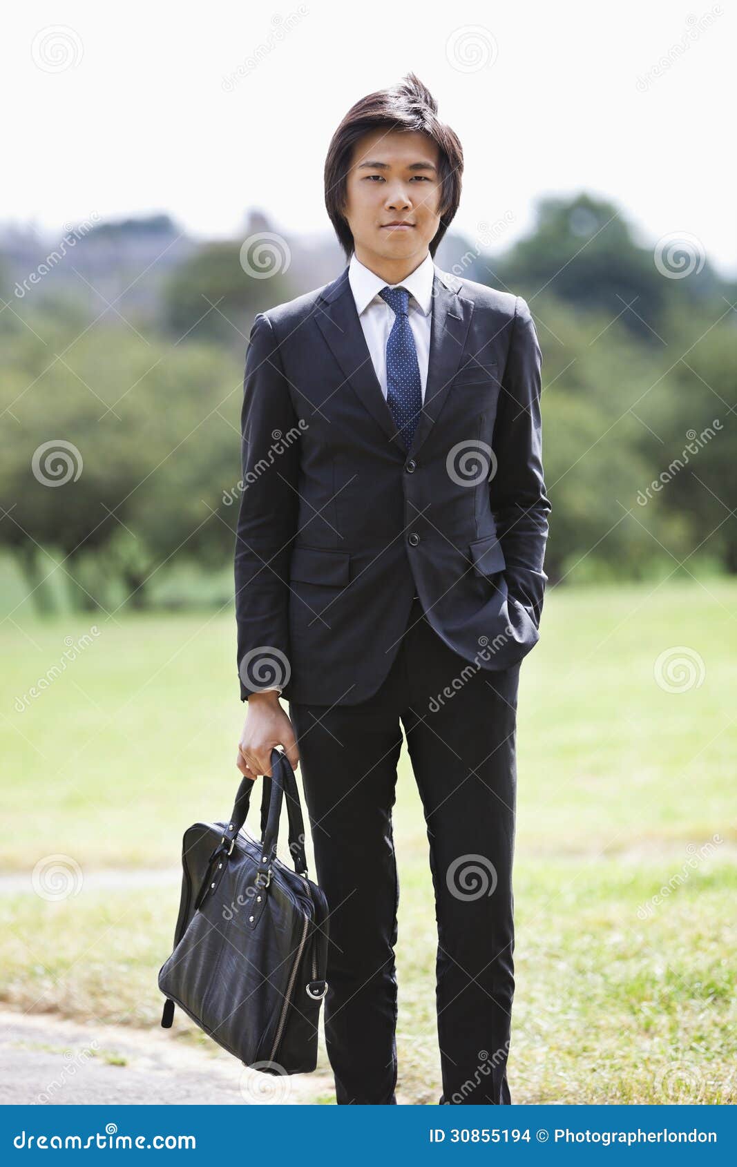 Portrait of Young Businessman Carrying Briefcase Standing at Park Stock ... Portrait of Young Businessman Carrying Briefcase Standing at Park Stock ...