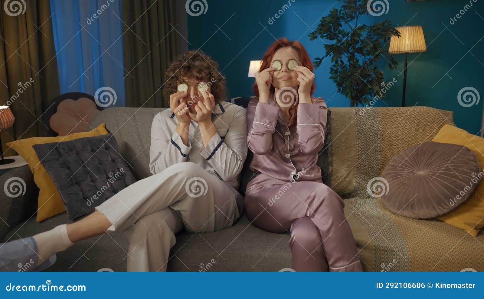 Portrait Of Young Couple Man And Woman Sitting On The Sofa Holding