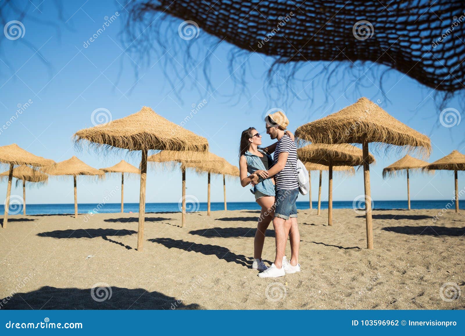 Young Couple Standing on Beach Cuddling Stock Photo - Image of ...
